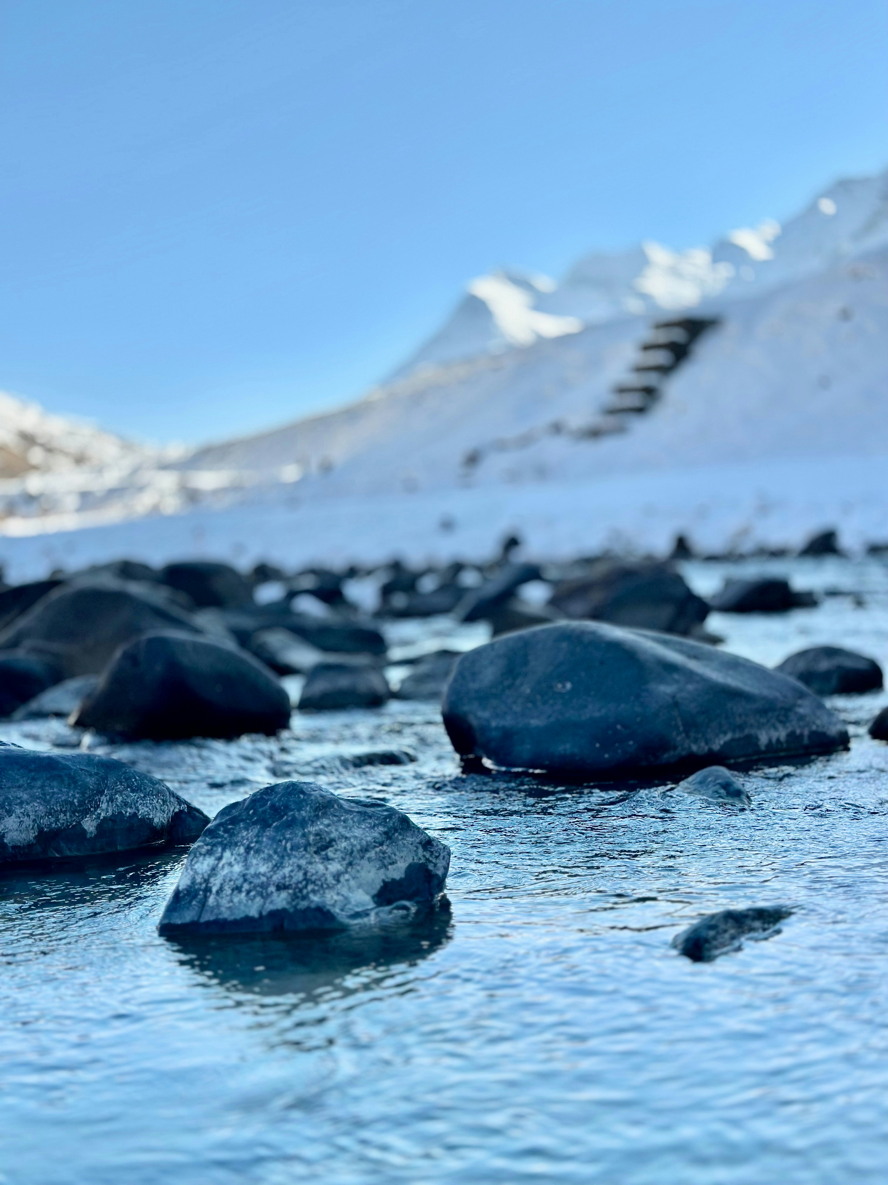 A stream of water surrounded by snow covered mountains photo – Free ...