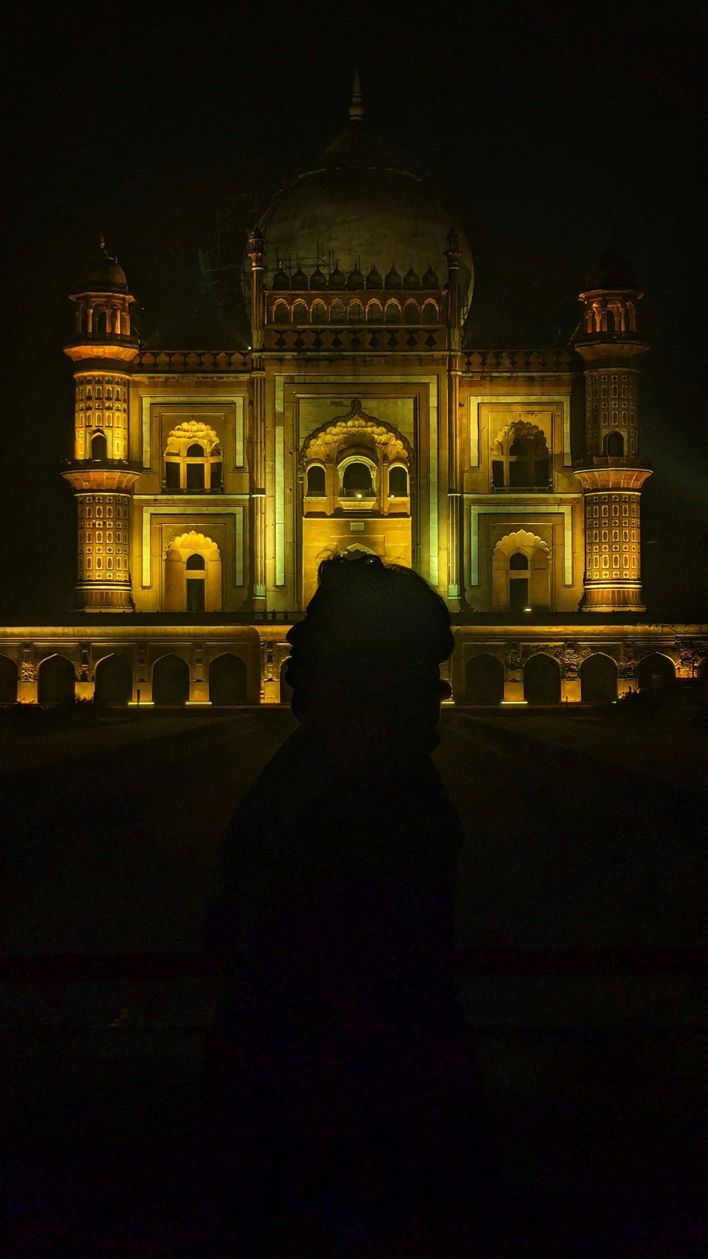 Golden Facade at Night Behind a Quiet Silhouette