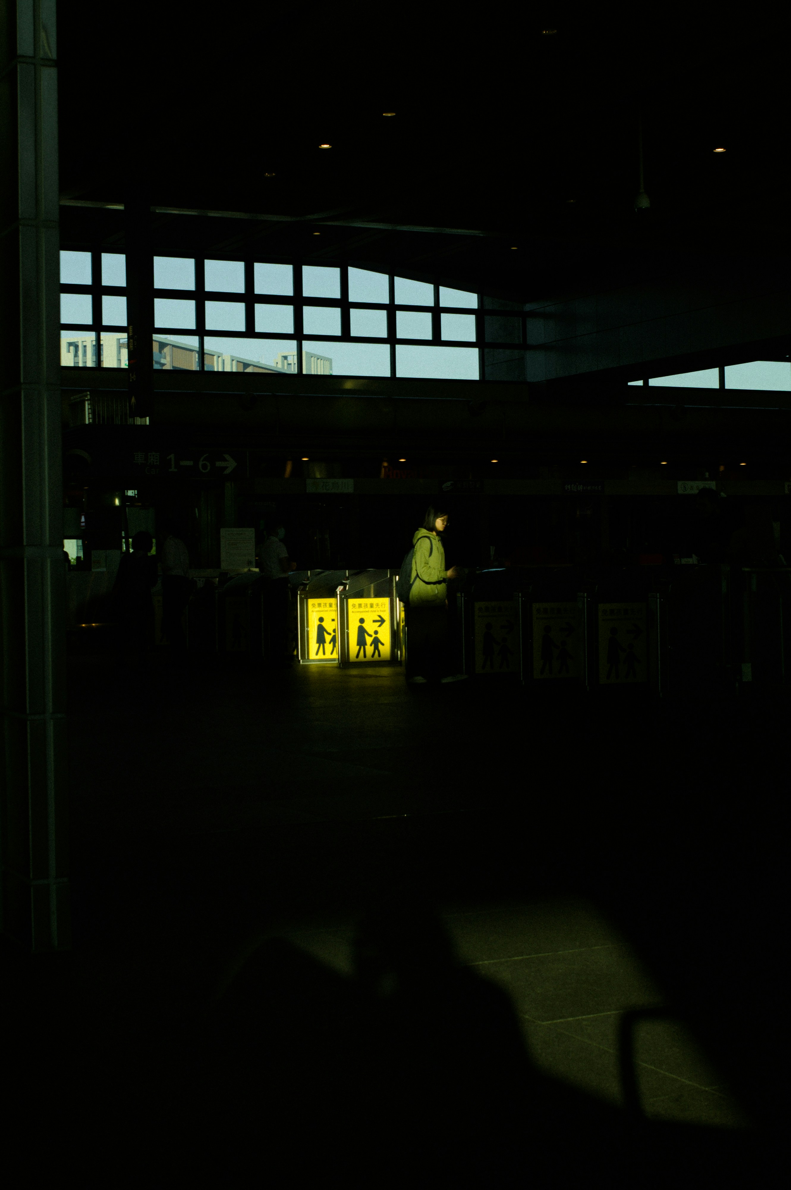 Beacon in the Dark: A Bright Pedestrian Sign Anchors a Quiet Transit Hall