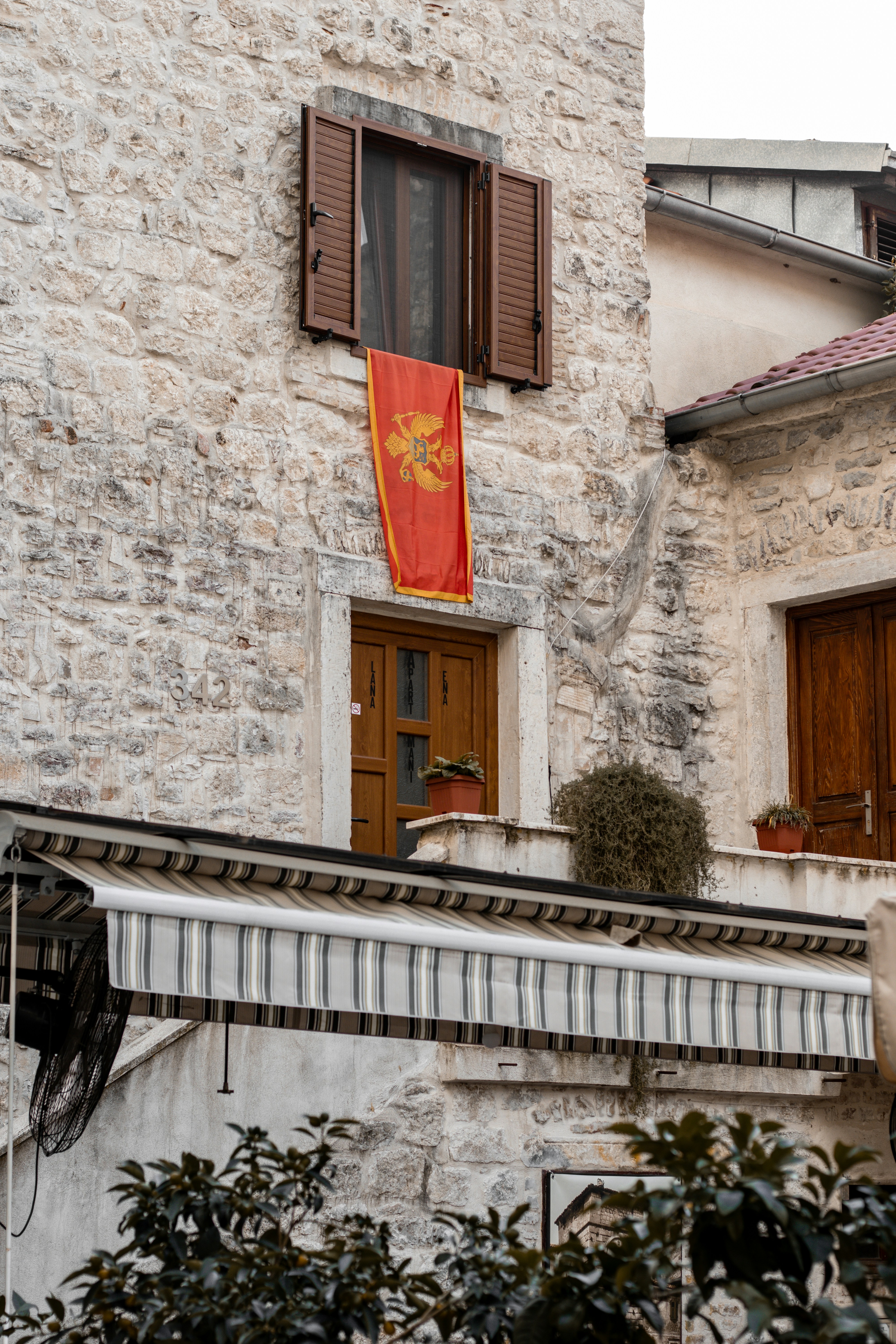 Crimson Crest Draped Over a Weathered Stone Facade