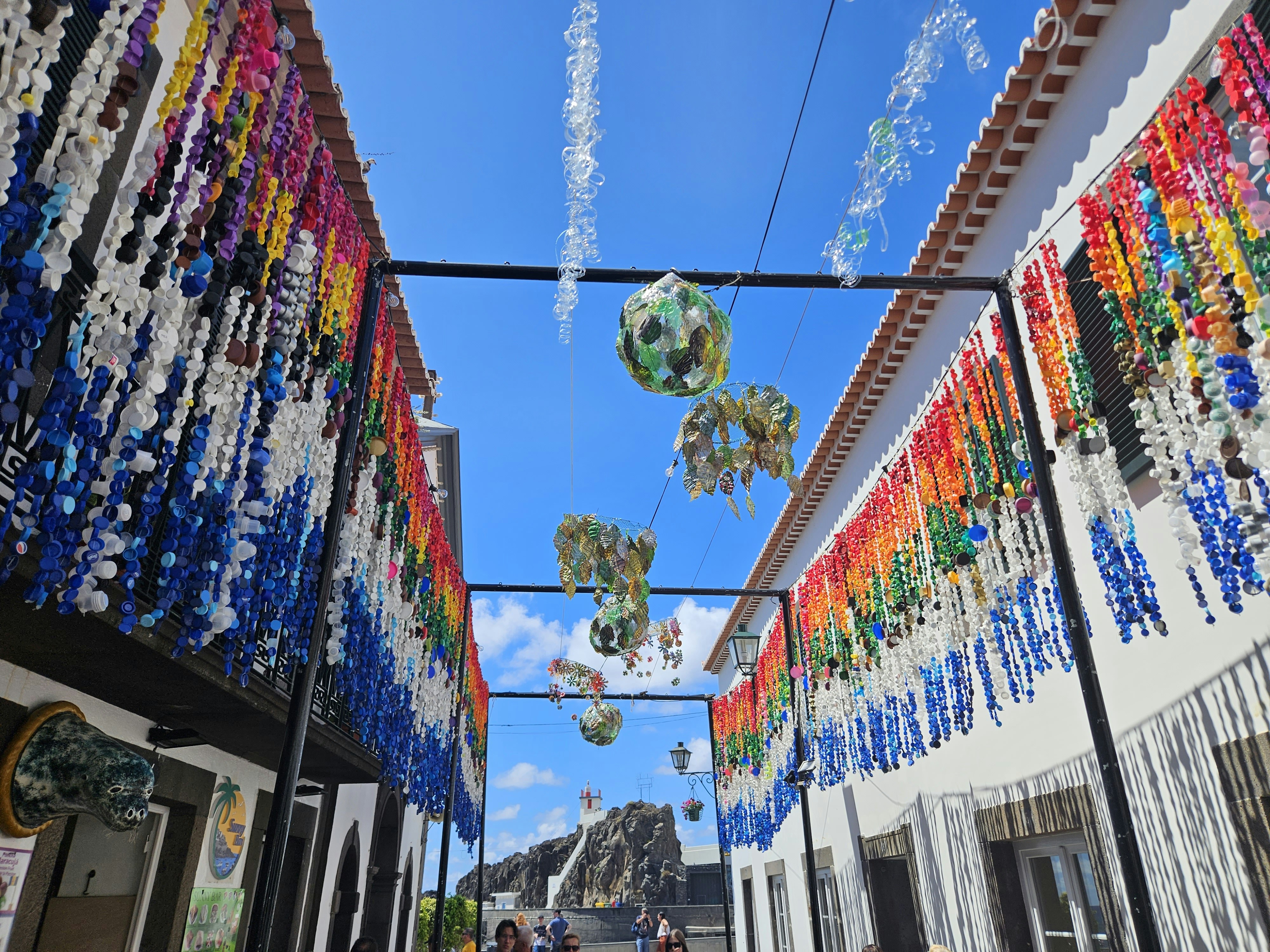 Glass Orbs Anchoring a Rainbow Corridor Under a Bright Sky