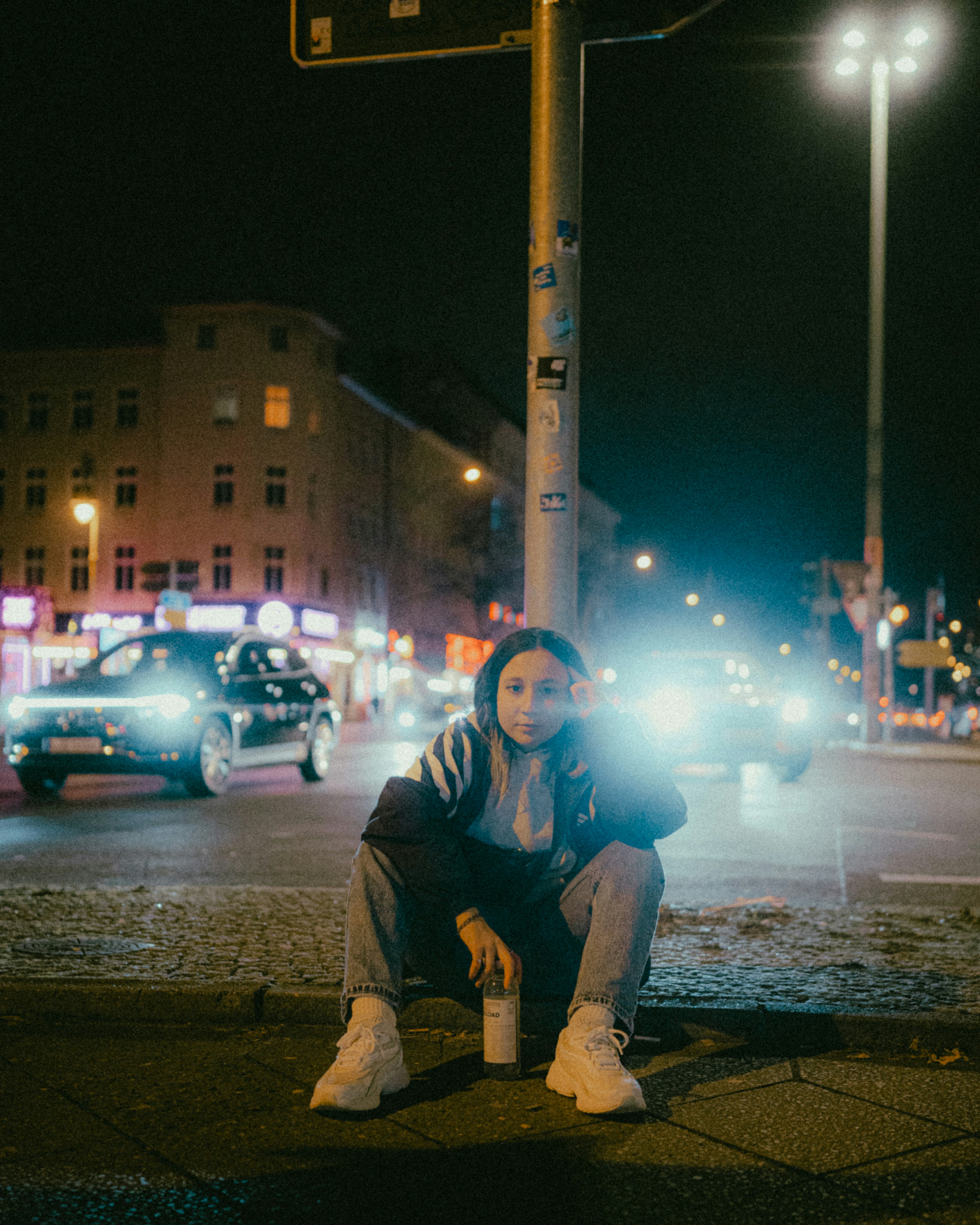 A person sitting on a curb at night photo – Free Berlin Image on Unsplash