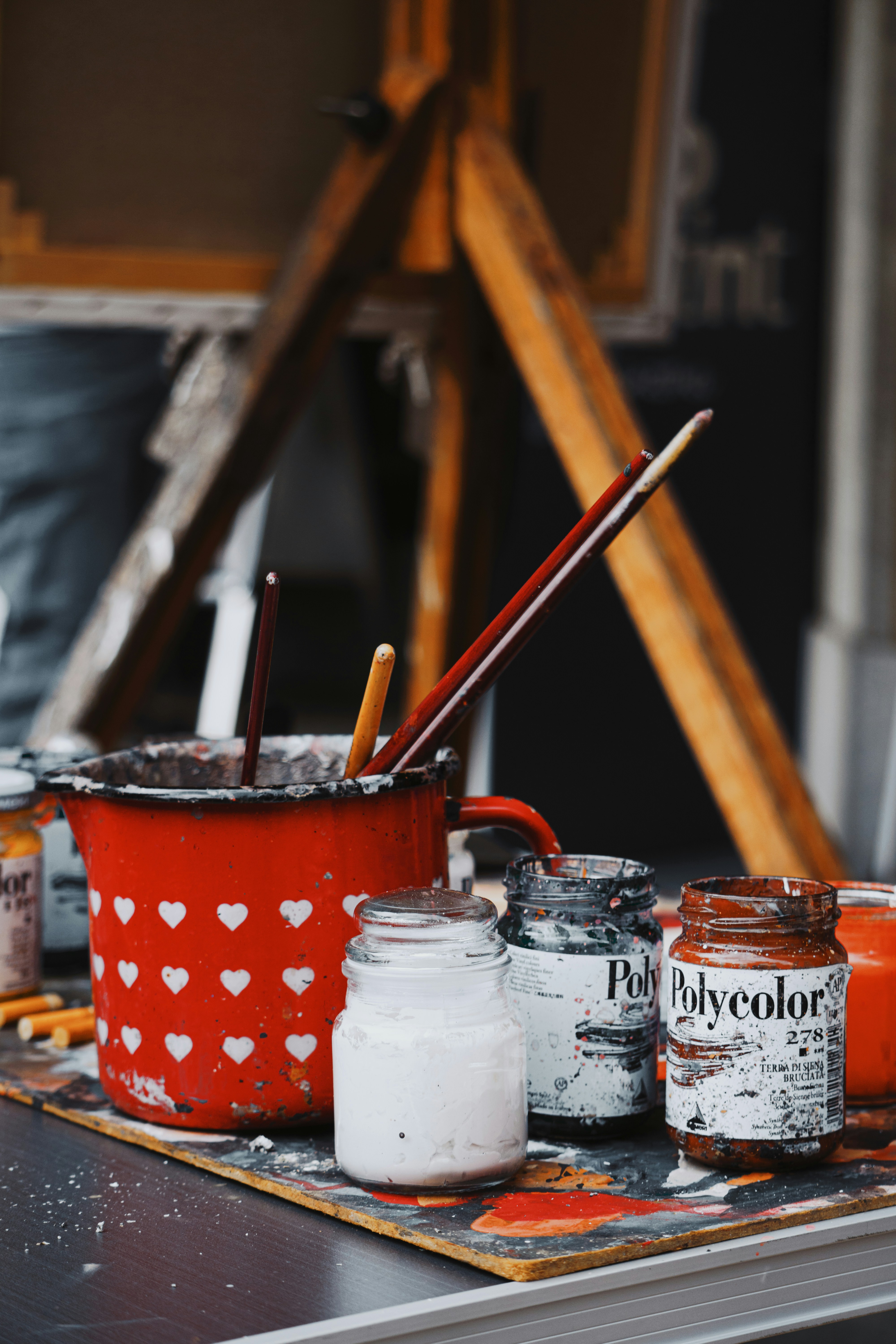 Heart-Patterned Red Pot Anchors a Quiet Studio Palette