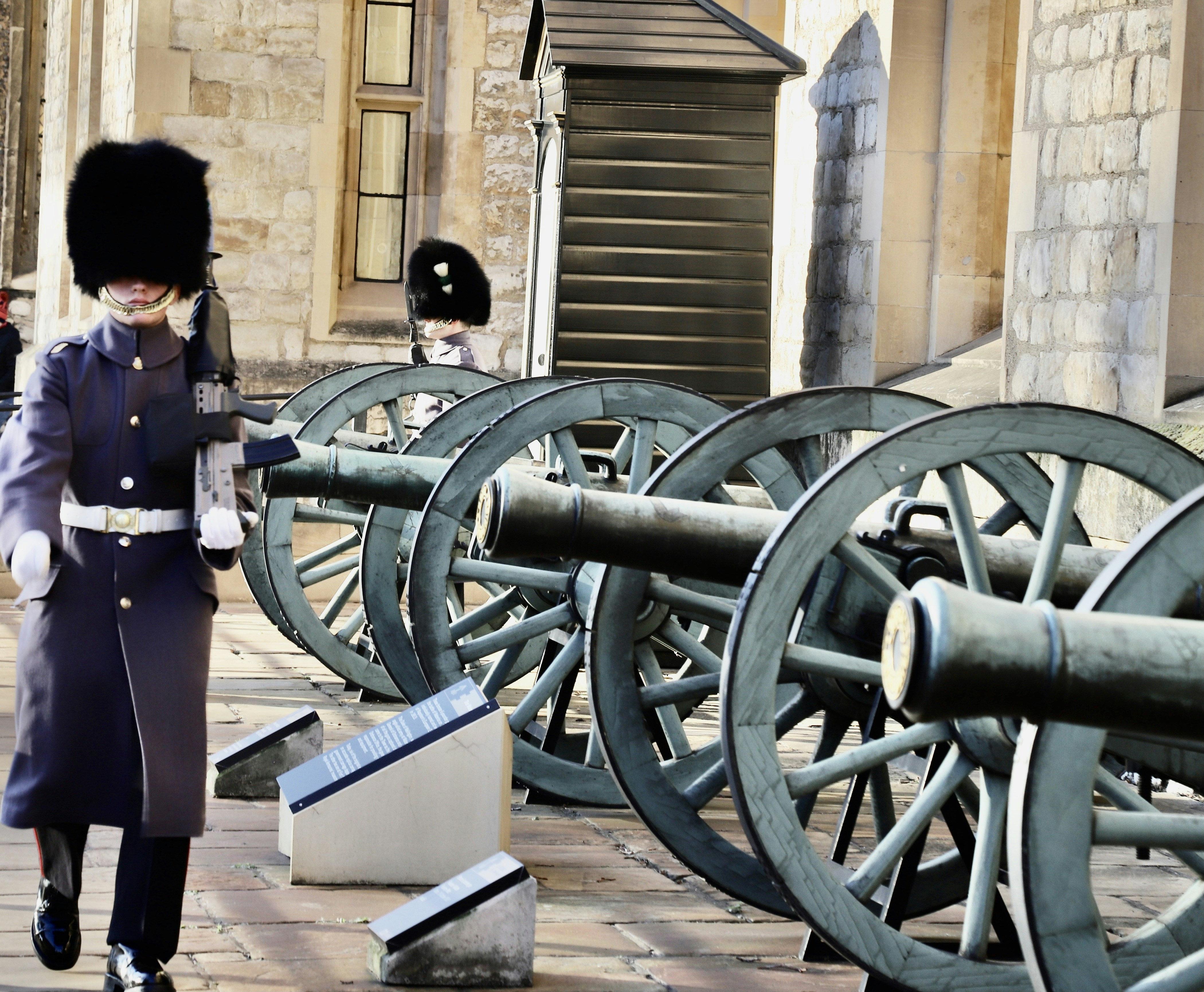 A man in uniform standing next to a row of cannon wheels photo – Free ...