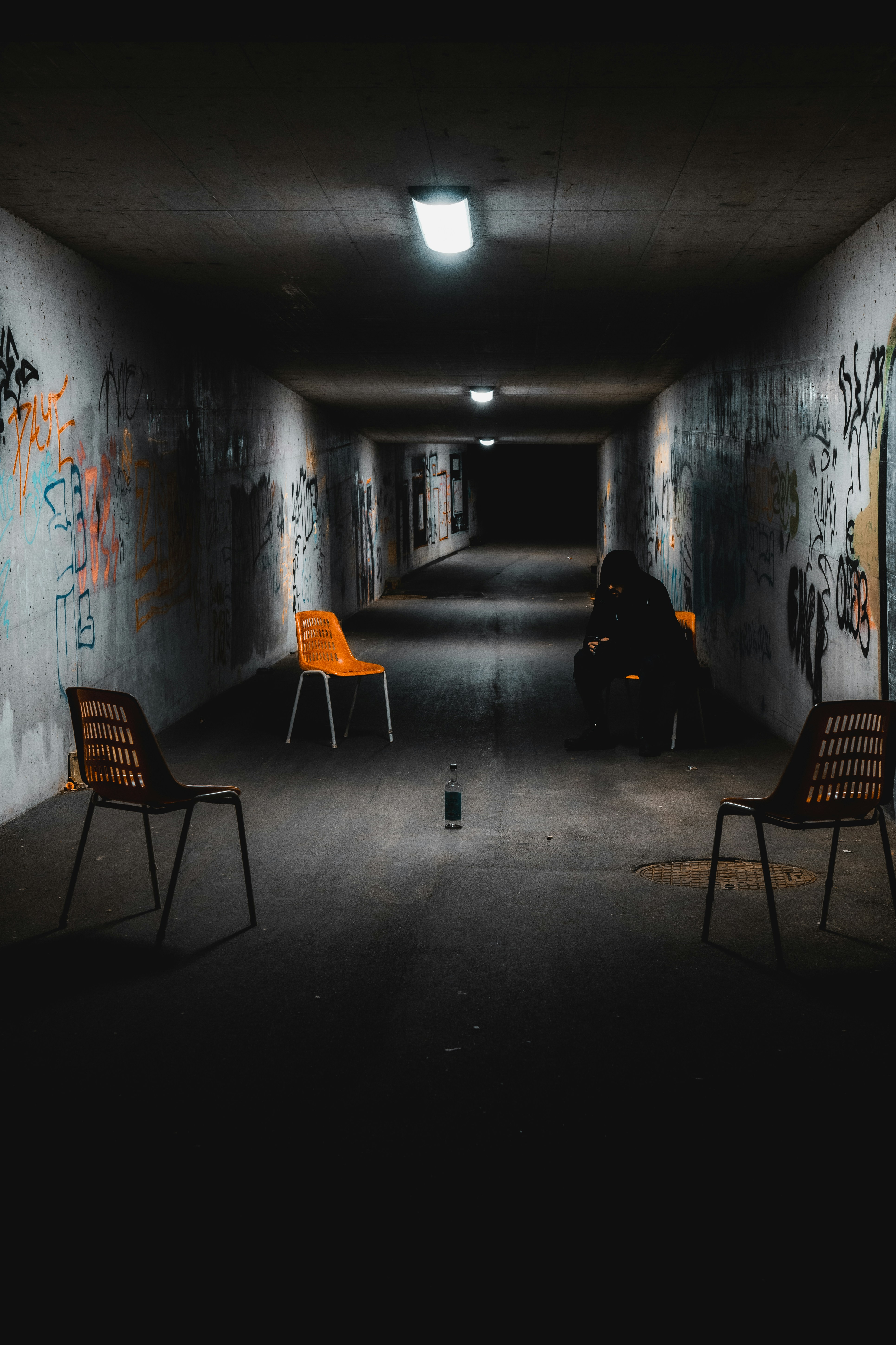 Two chairs in a dark tunnel with graffiti on the walls photo – Free ...