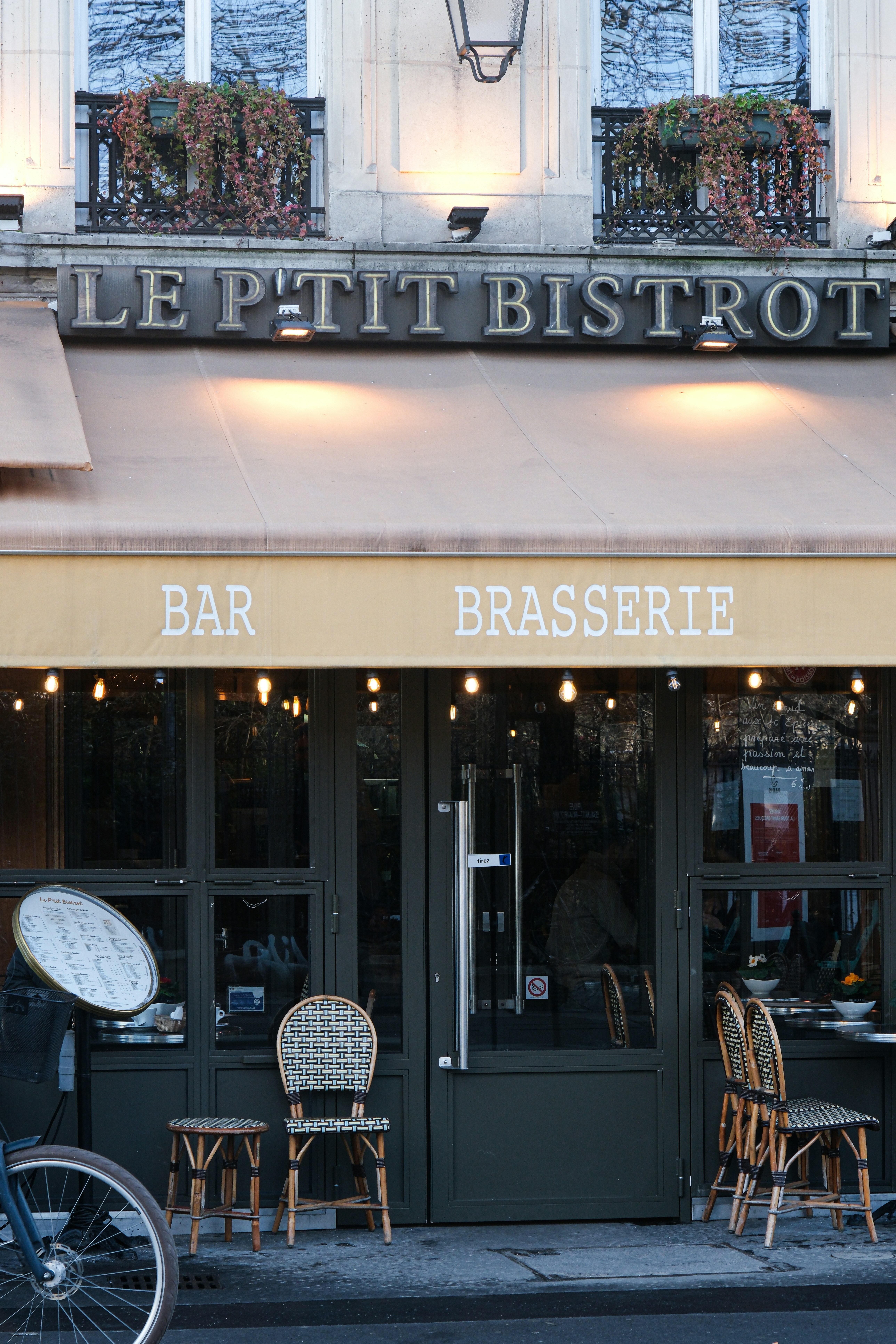 a bicycle parked outside of a restaurant with a sign on the front
