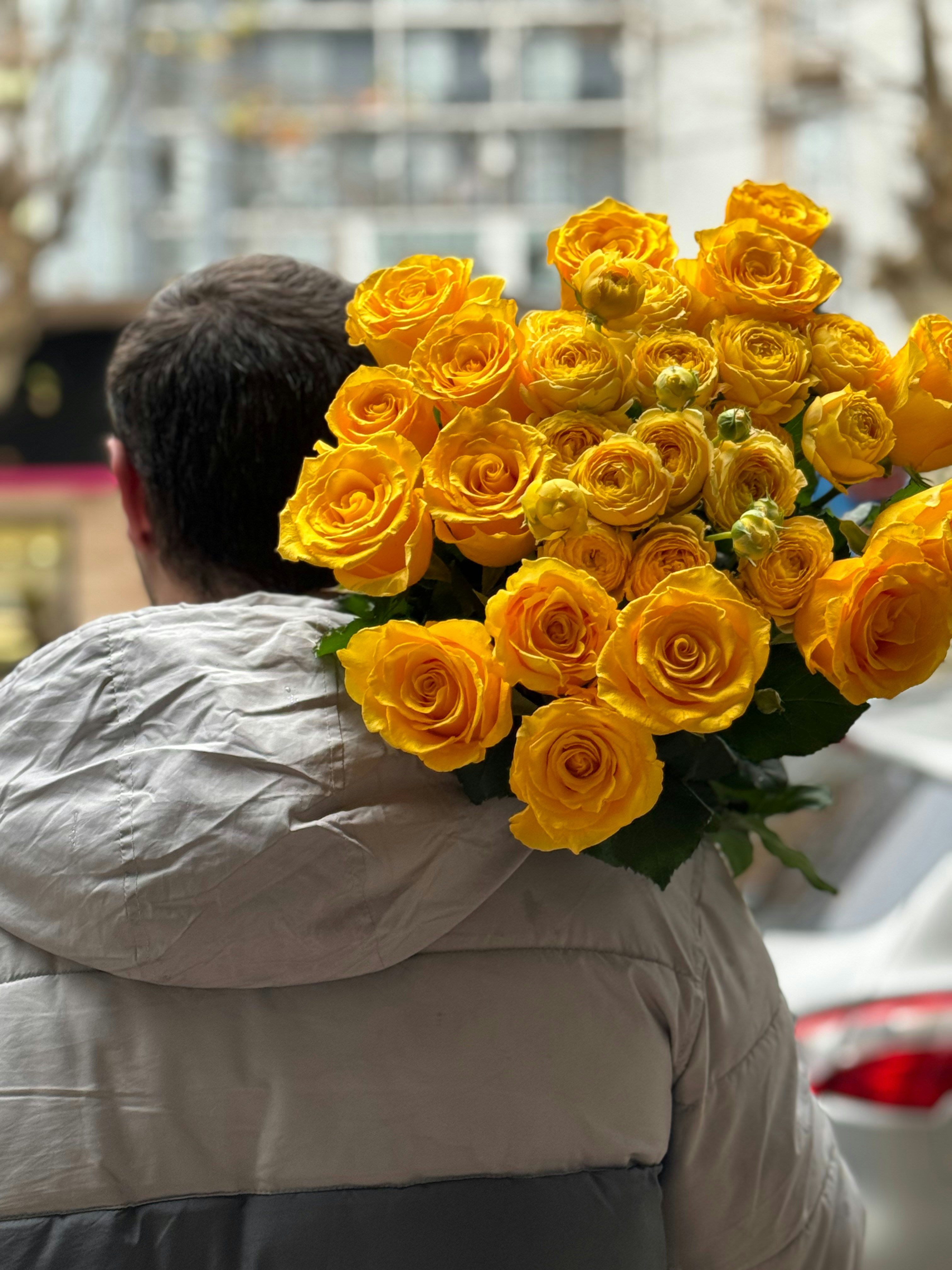 A man carrying a bouquet of yellow roses on his back photo – Free ...