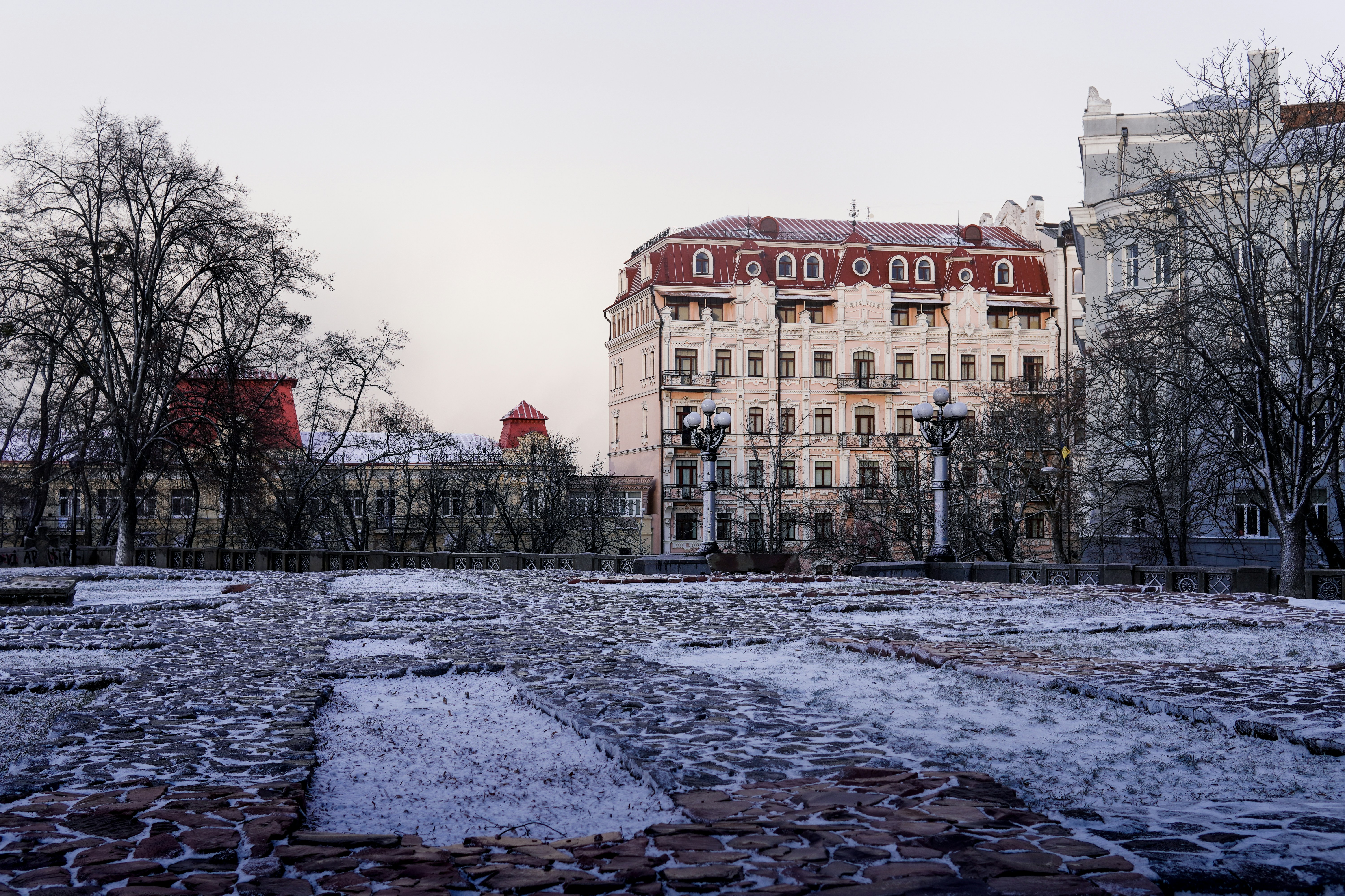 Snow-Dusted Plaza Guides the Eye to a Red-Roofed European Facade