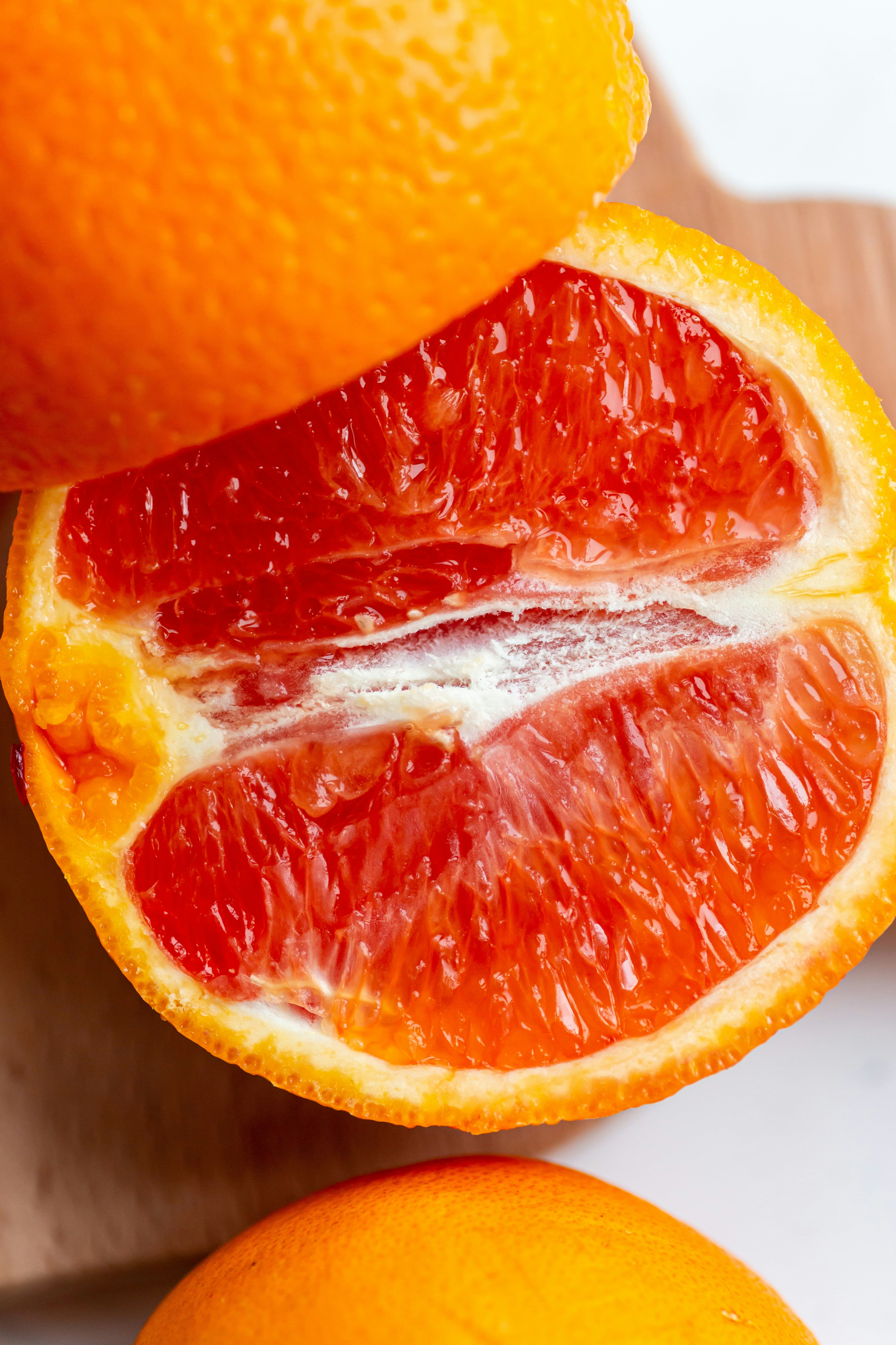 A blood orange cut in half on a cutting board photo – Free Fruit Image ...