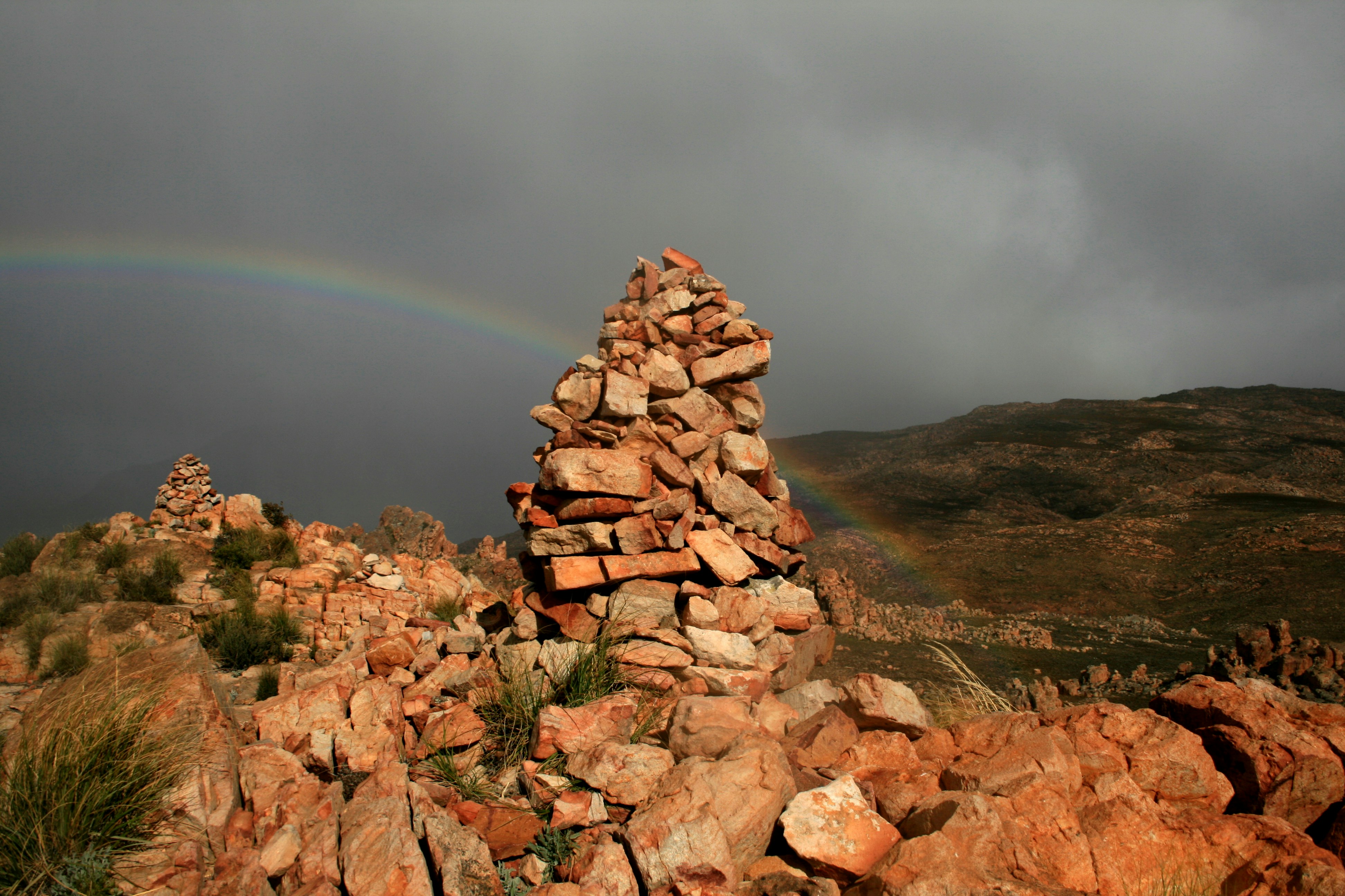 Un tas de roches avec un arc-en-ciel en arrière-plan photo – Image ...