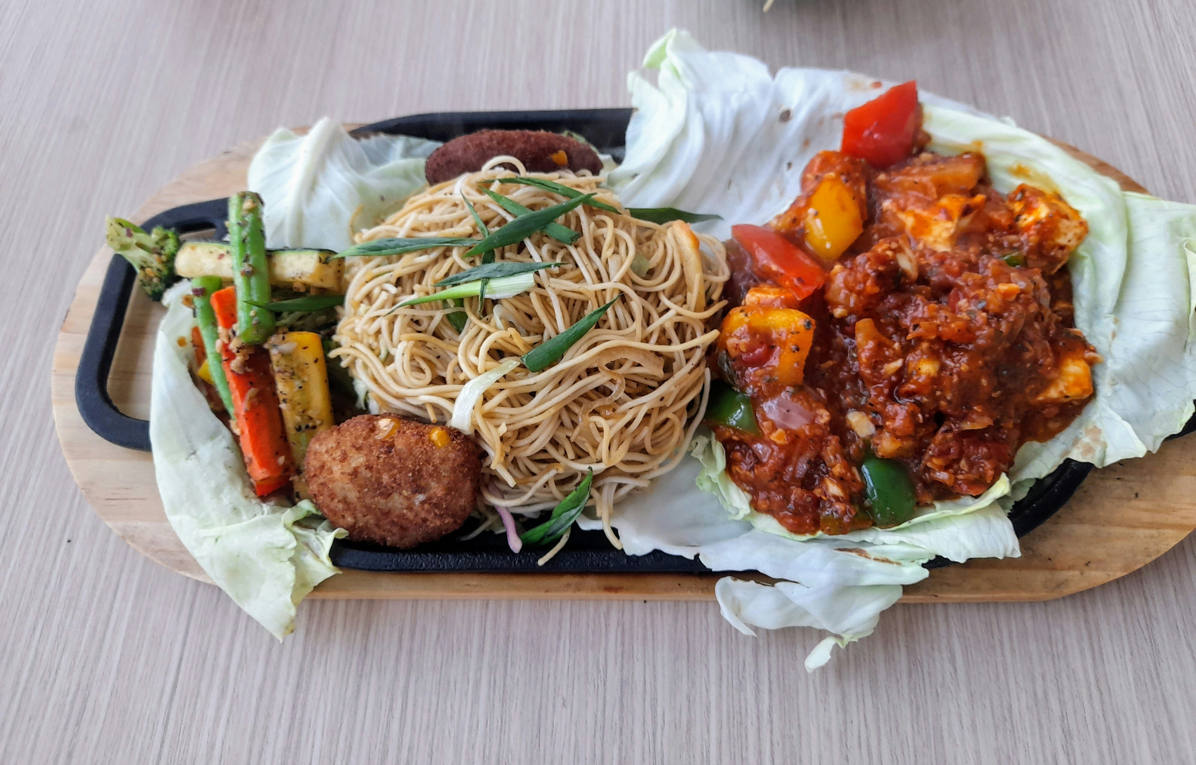 A plate of food with noodles, meat and vegetables photo – Free Food ...