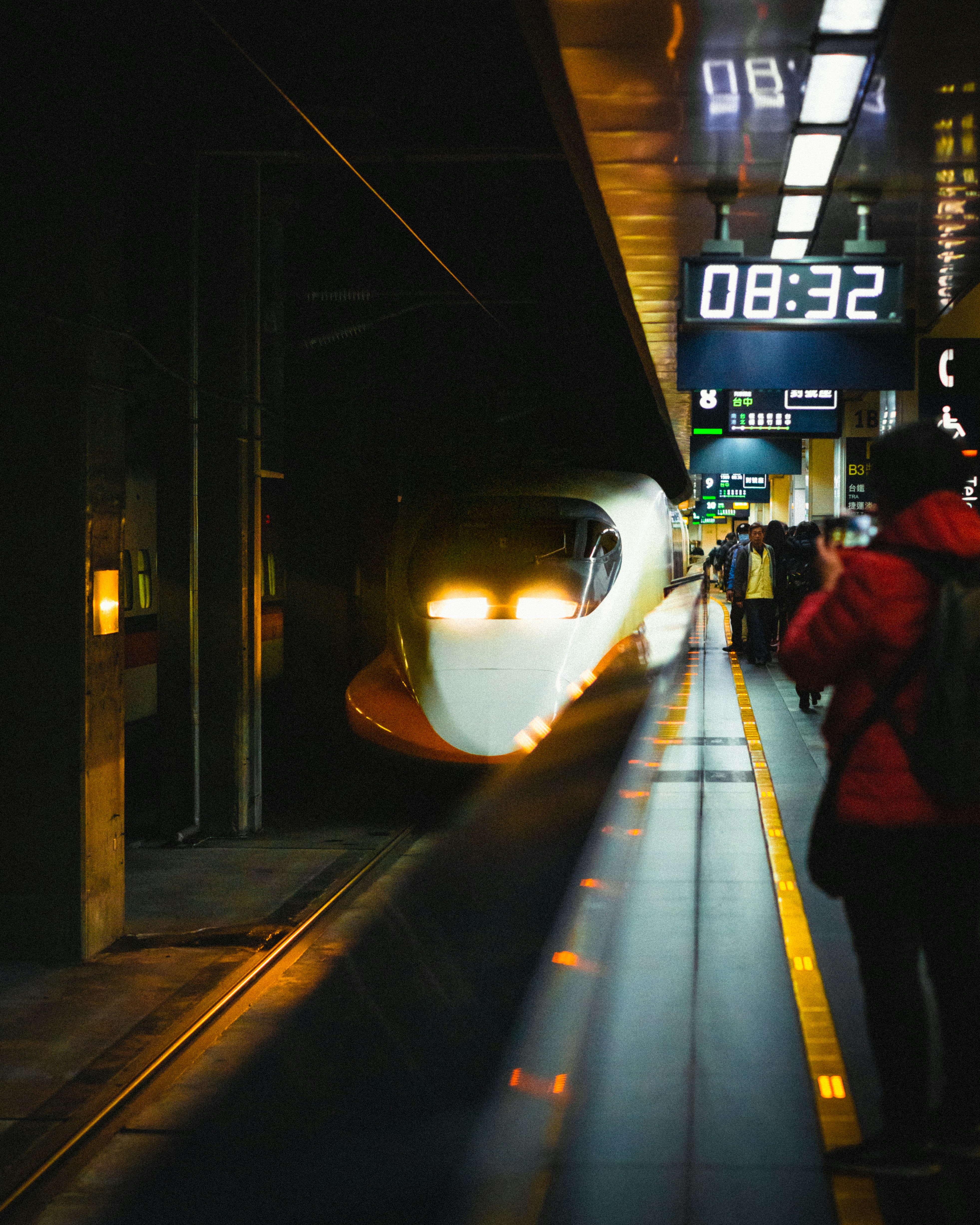A train pulling into a train station at night photo – Free Taipei Image ...