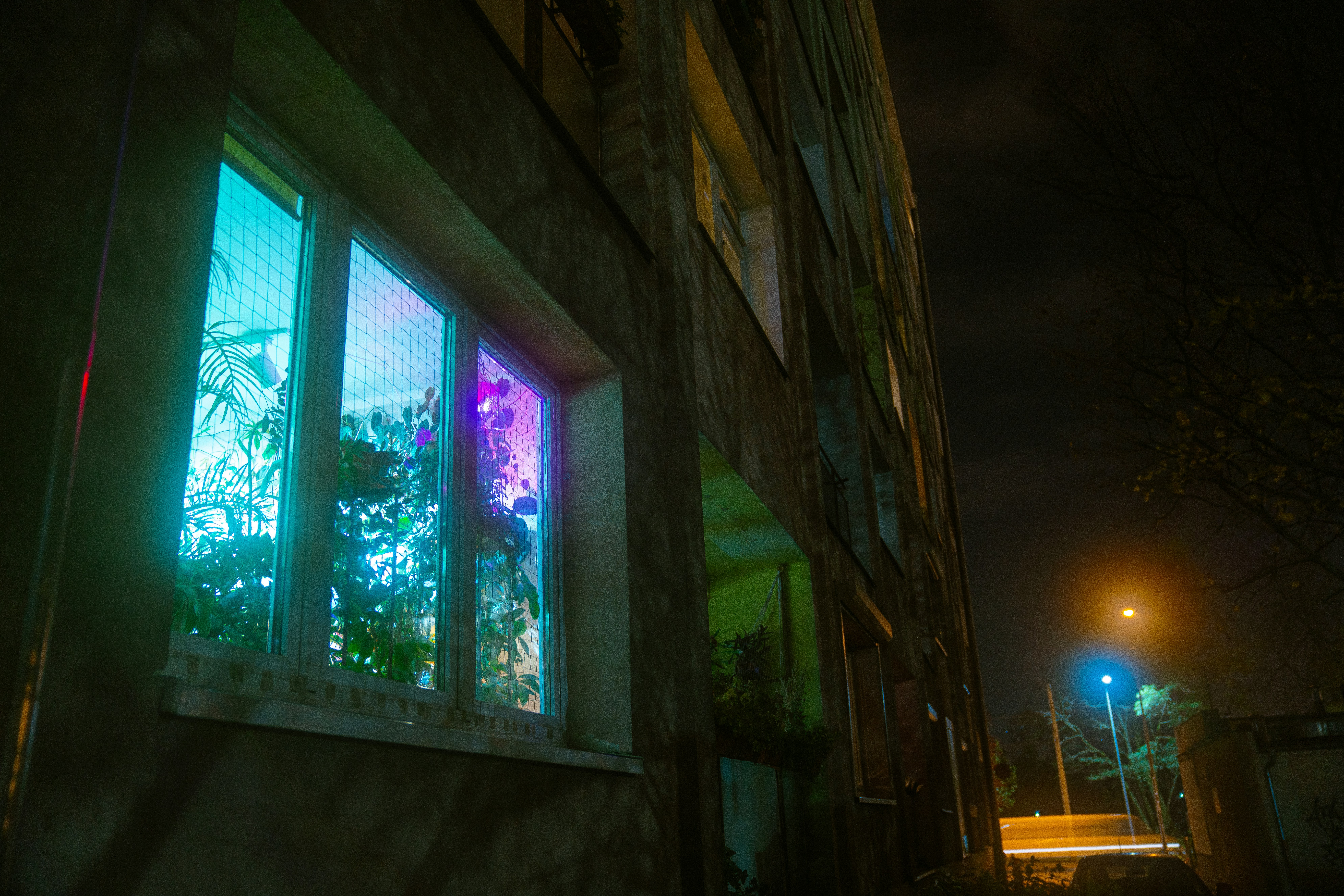 A building with a lit up window in the middle of it photo – Free ...