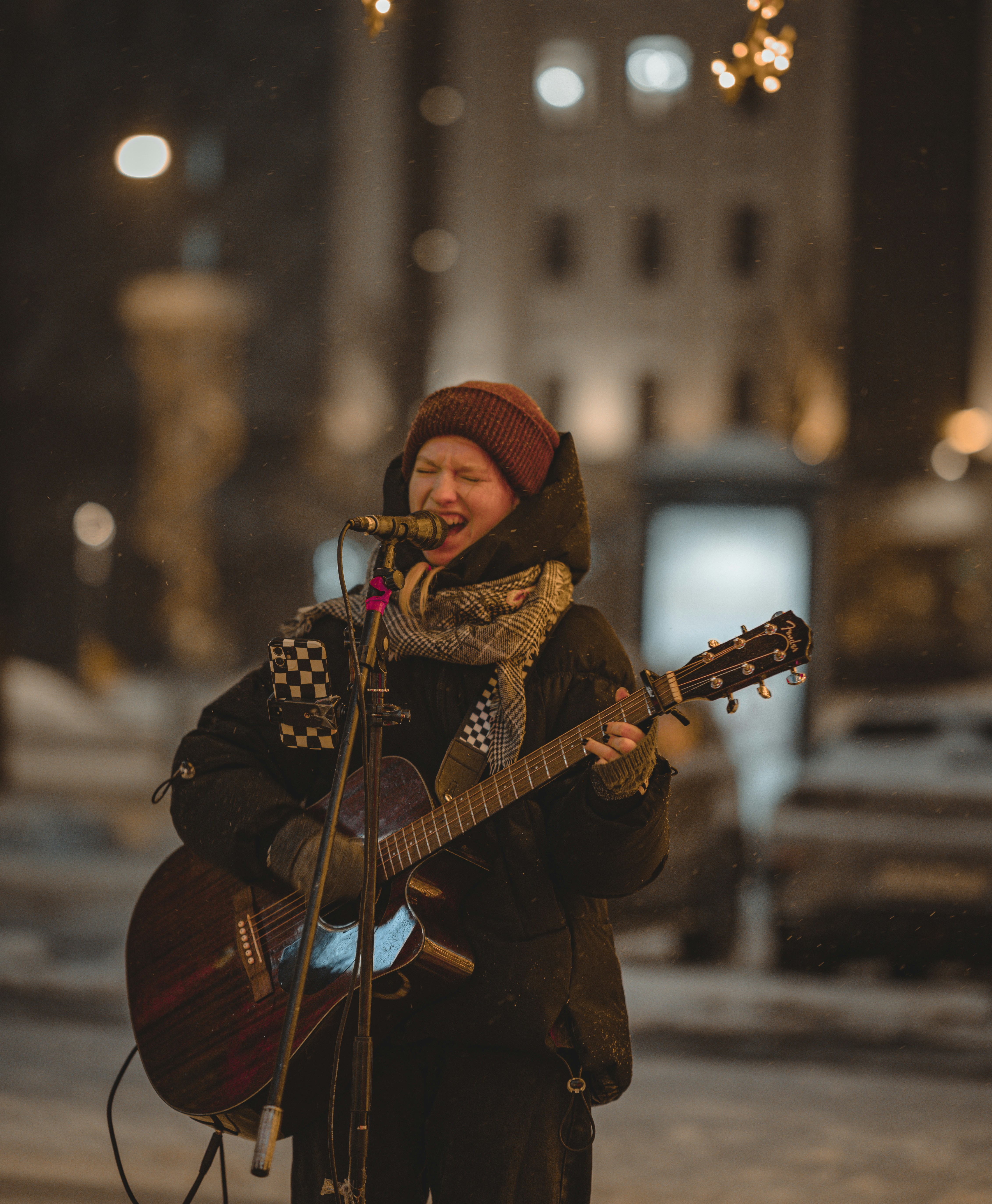 Winter Boulevard Serenade: A Busker Under Warm Night Lights
