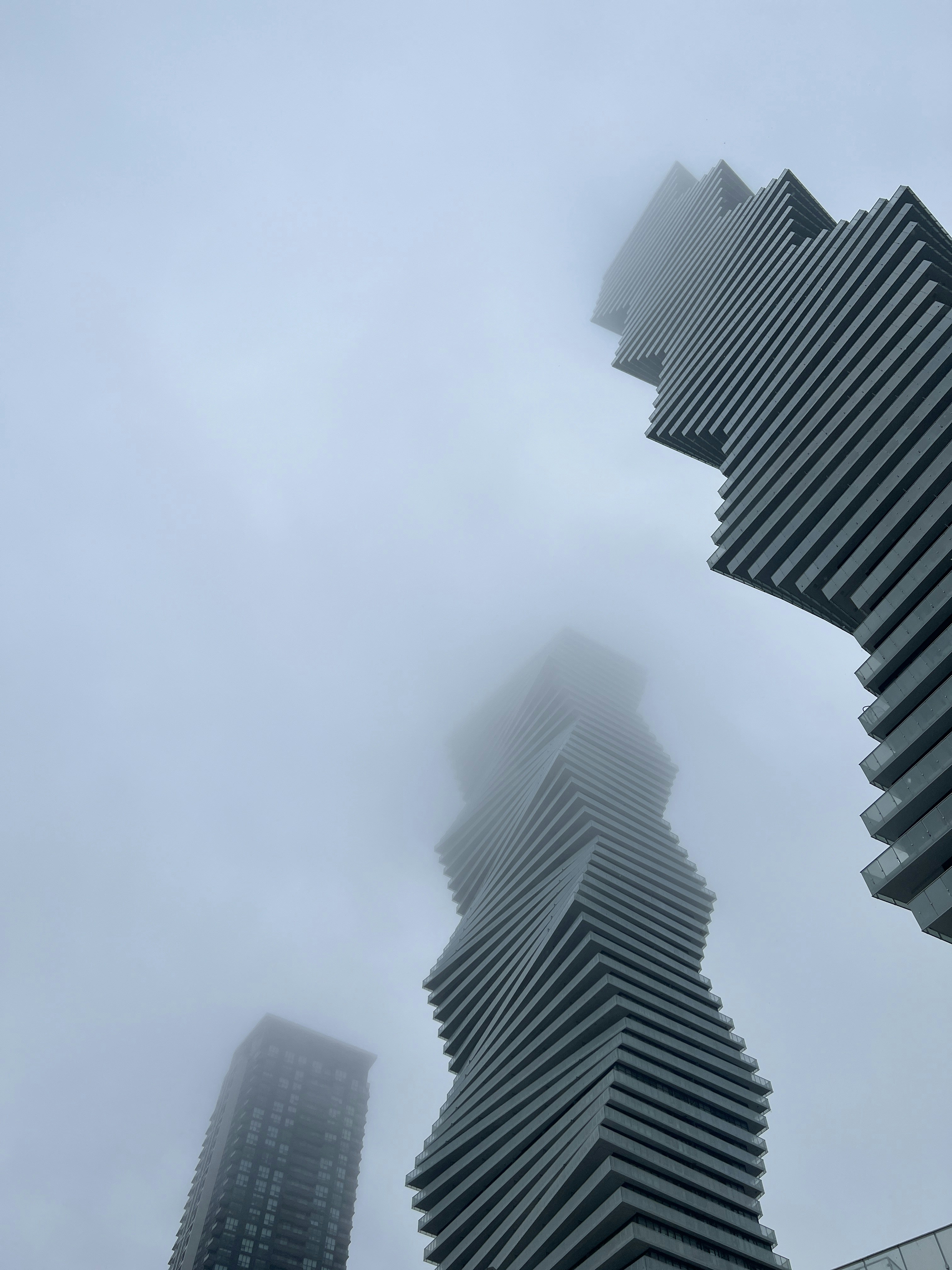 Spiral Skyscrapers Ascend Through Thick Fog