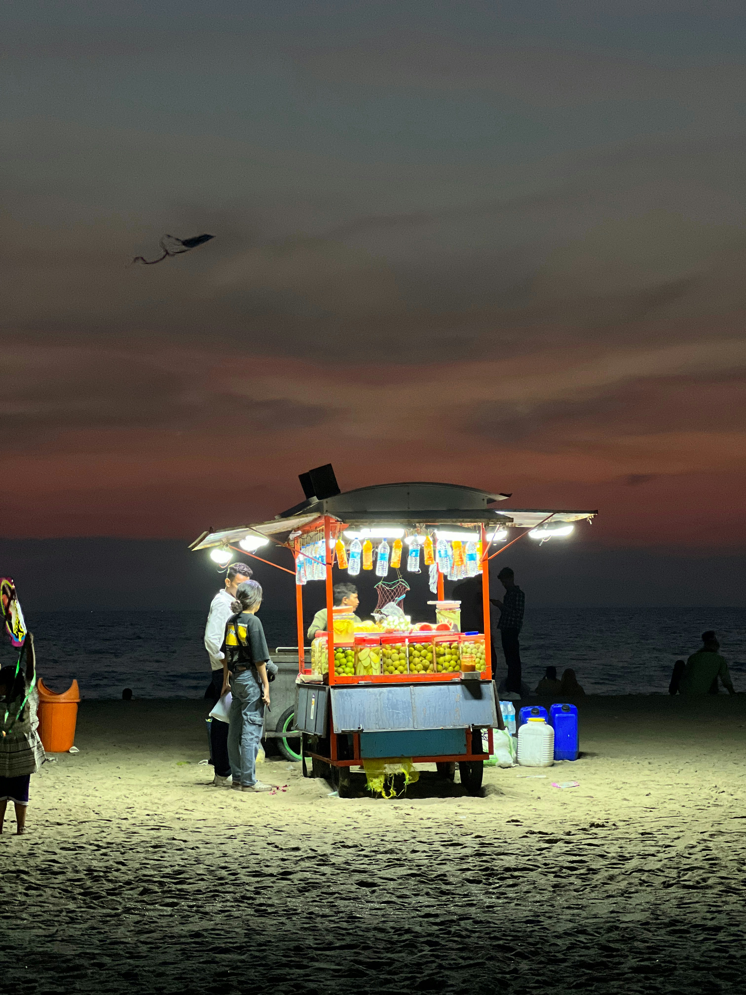 Dusk Glow: Beachside Fruit Cart Illuminated by Sunset