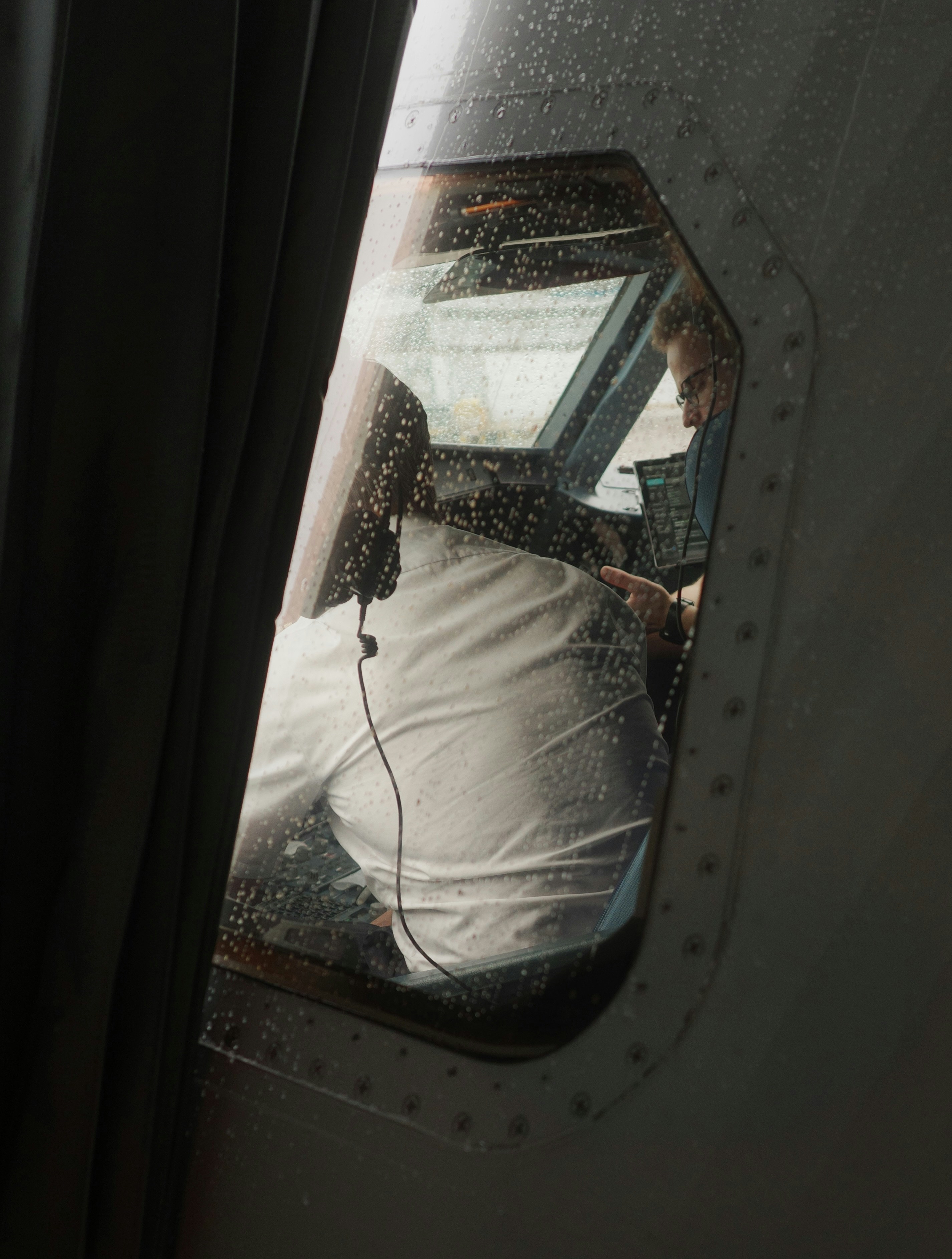a man sitting in a plane looking out the window