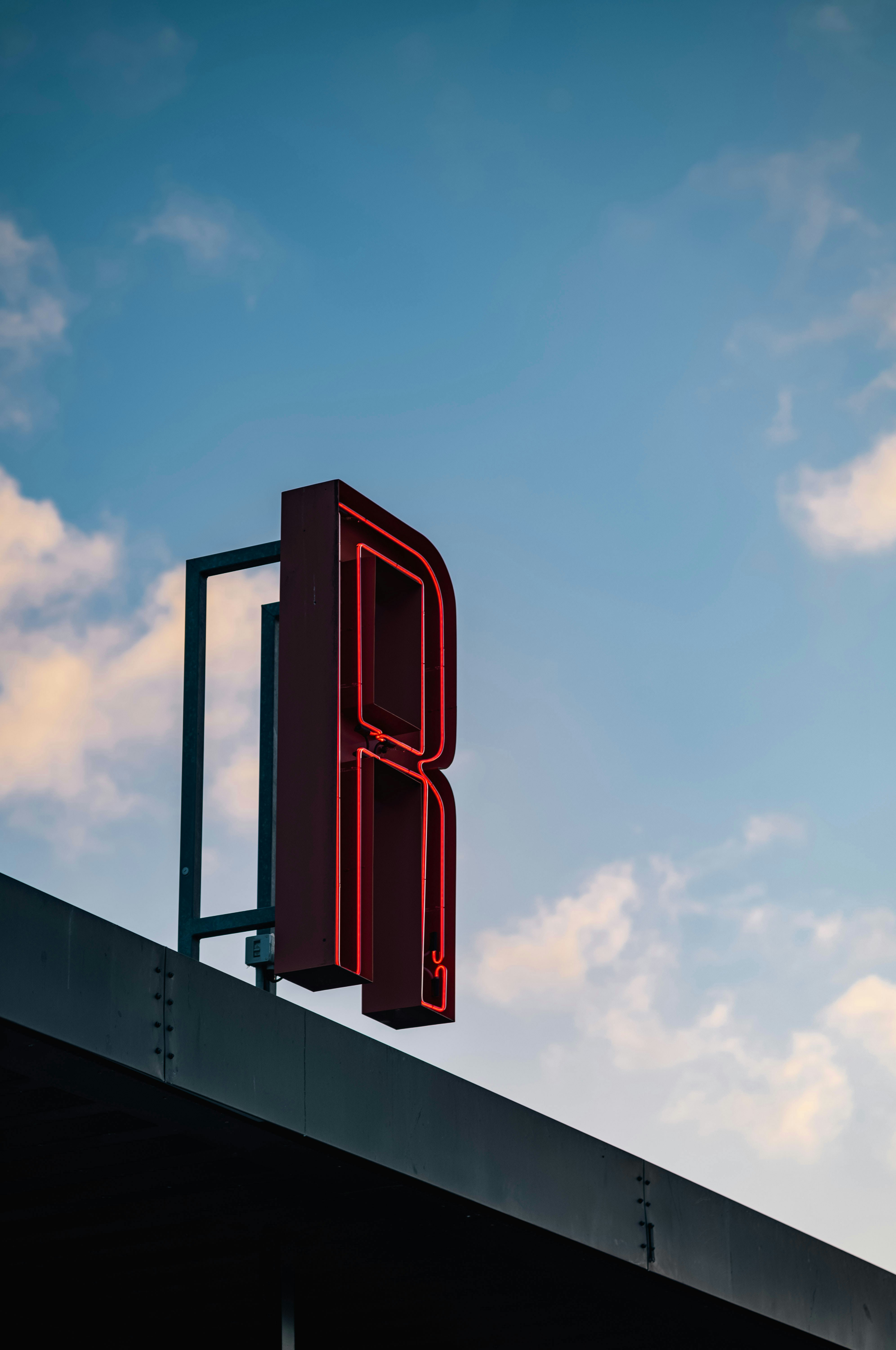 A red neon sign on top of a building photo – Free Blue Image on Unsplash