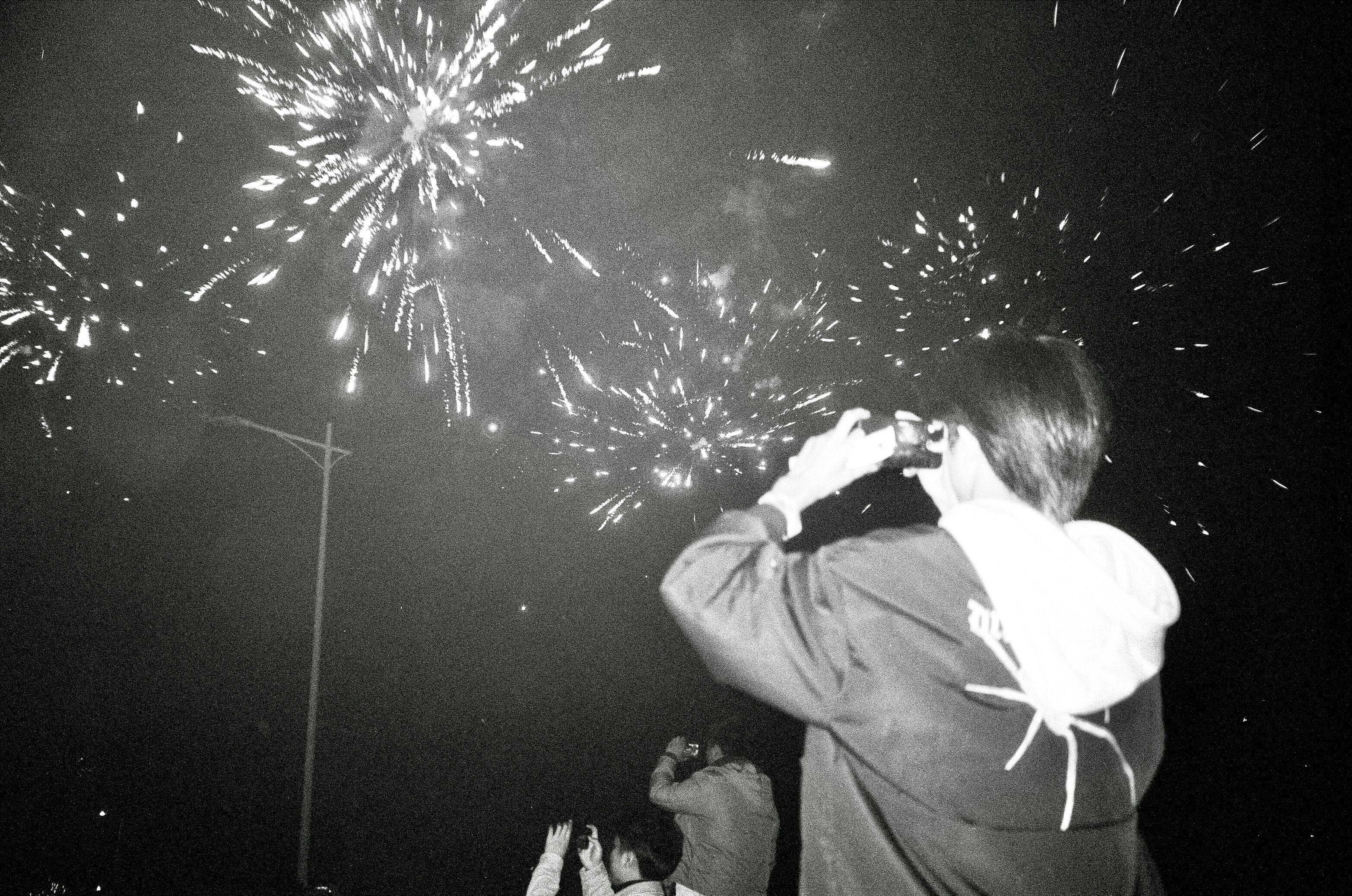 A person taking a picture of a fireworks display photo – Free Portrait Image on Unsplash