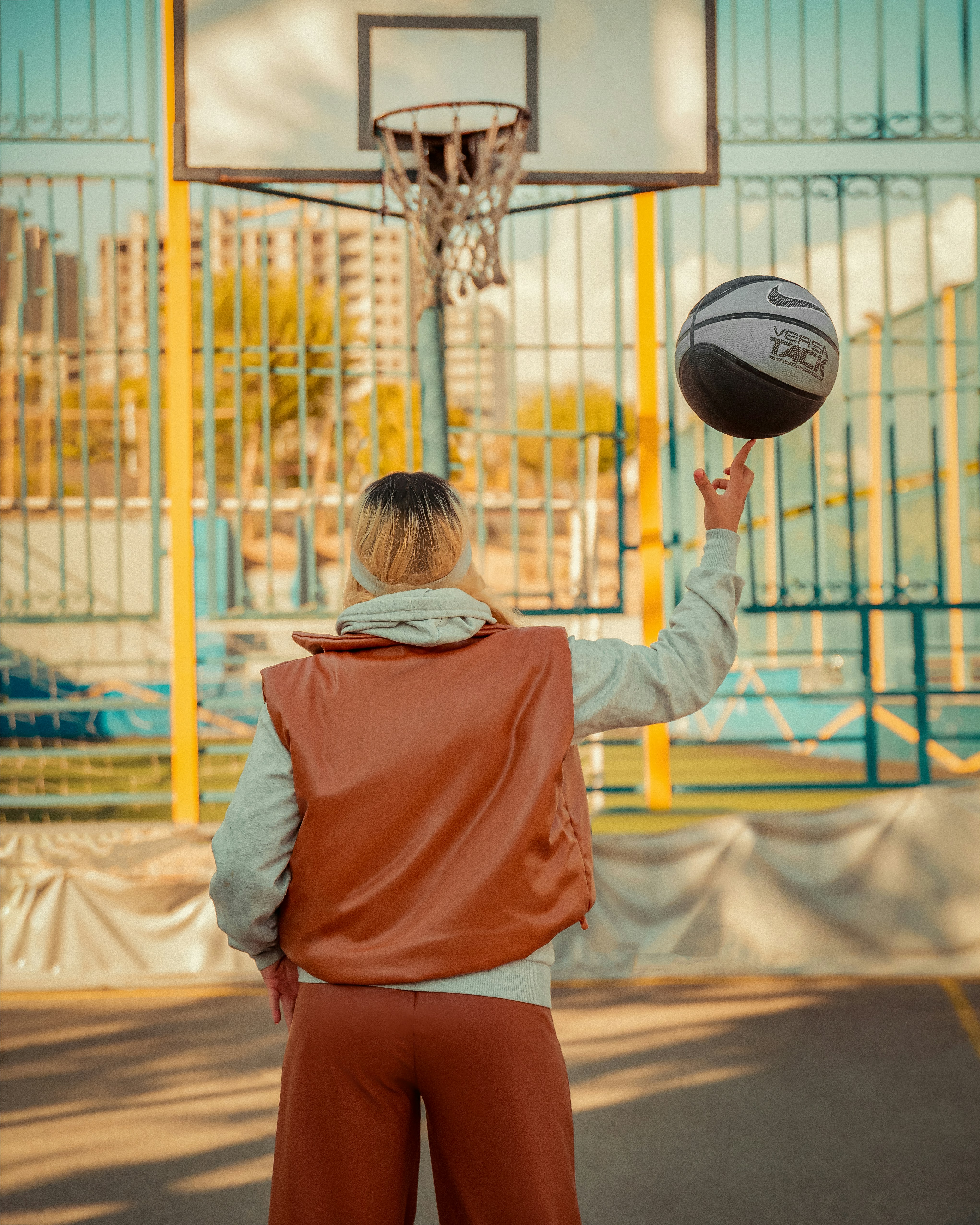 Urban Court Ballet: The Orange Vest Aligns with the Hoop