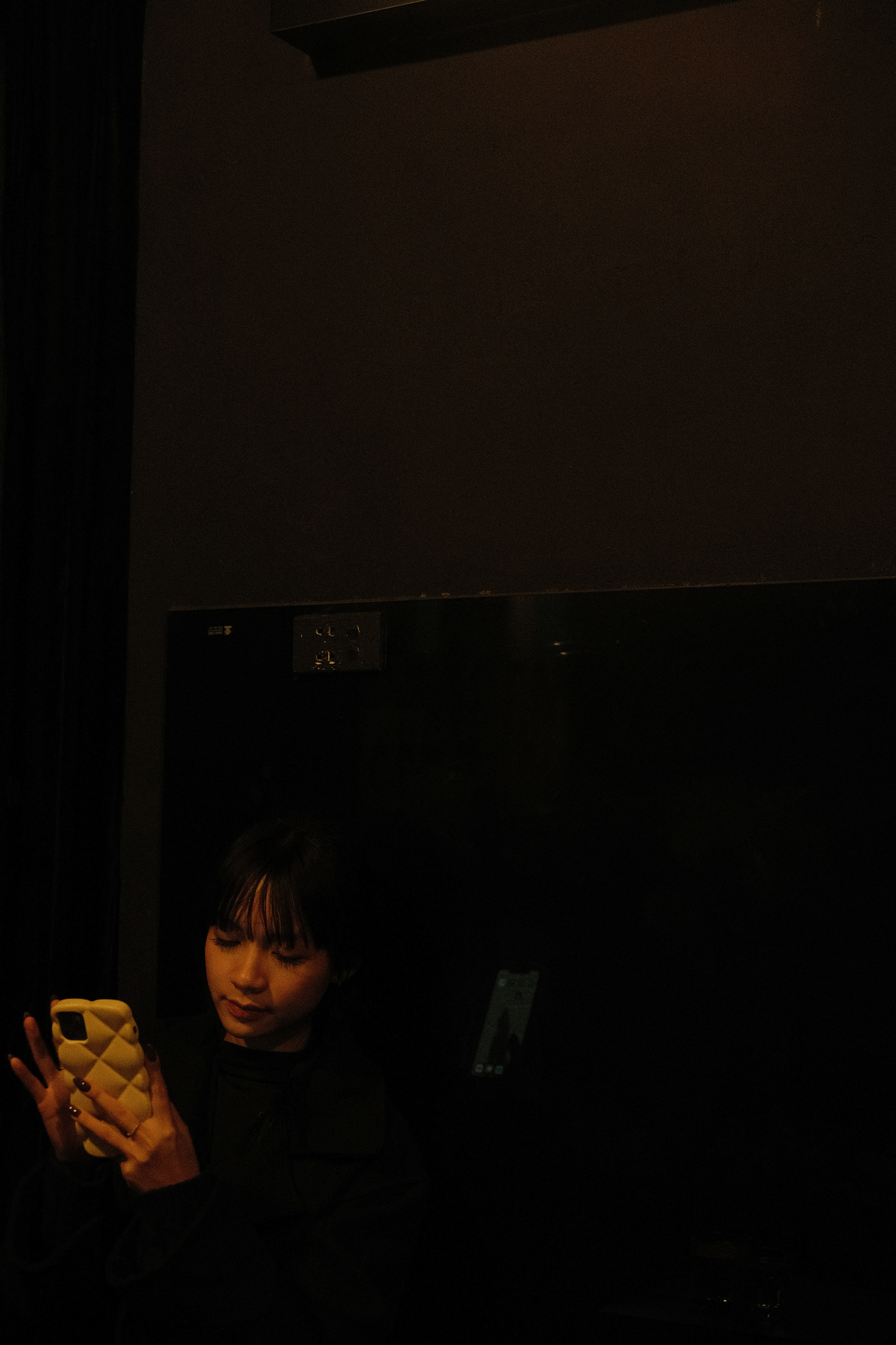 Amber Glow Portrait: Low-Light Moment with a Quilted Phone Case