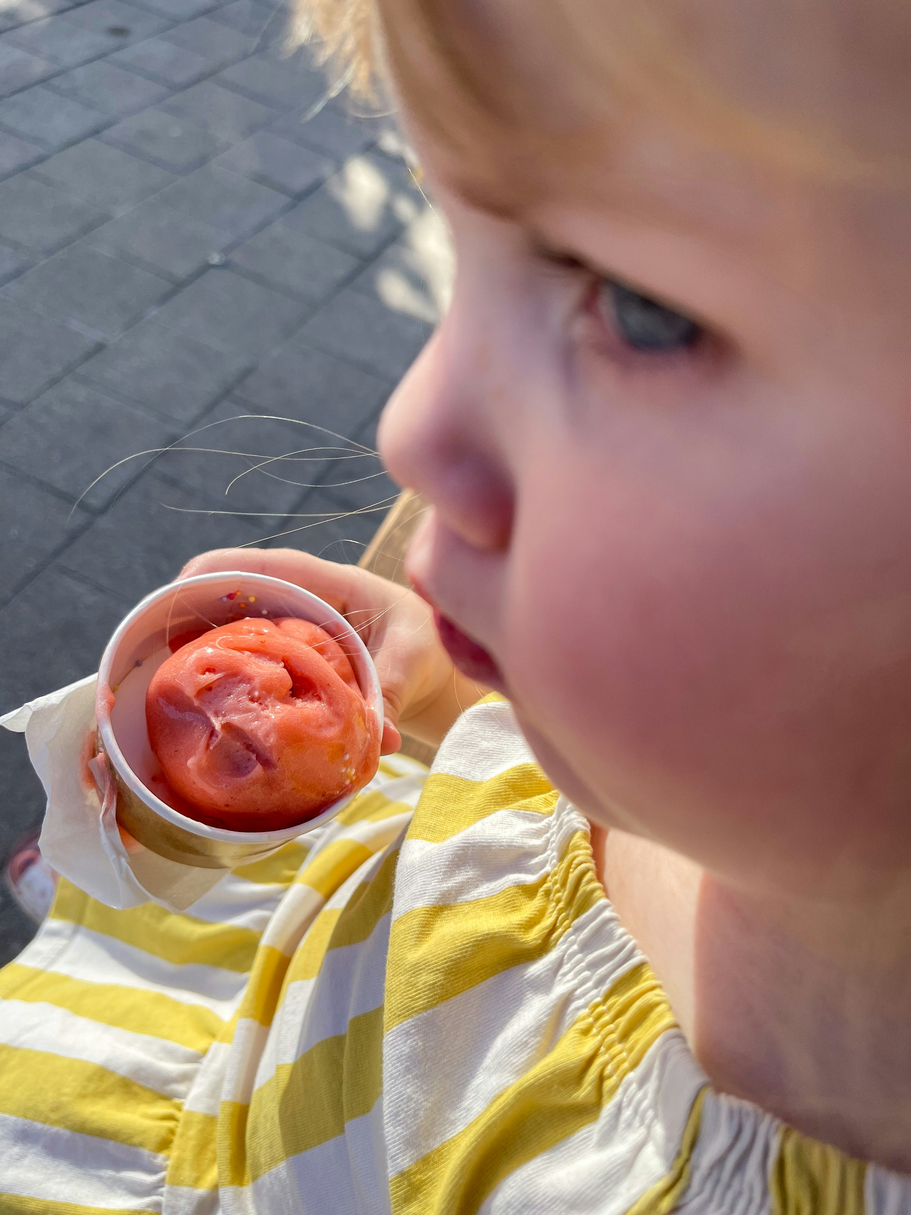 Sunlit Peach Sorbet Close-Up: A Child’s Quiet Summer Moment