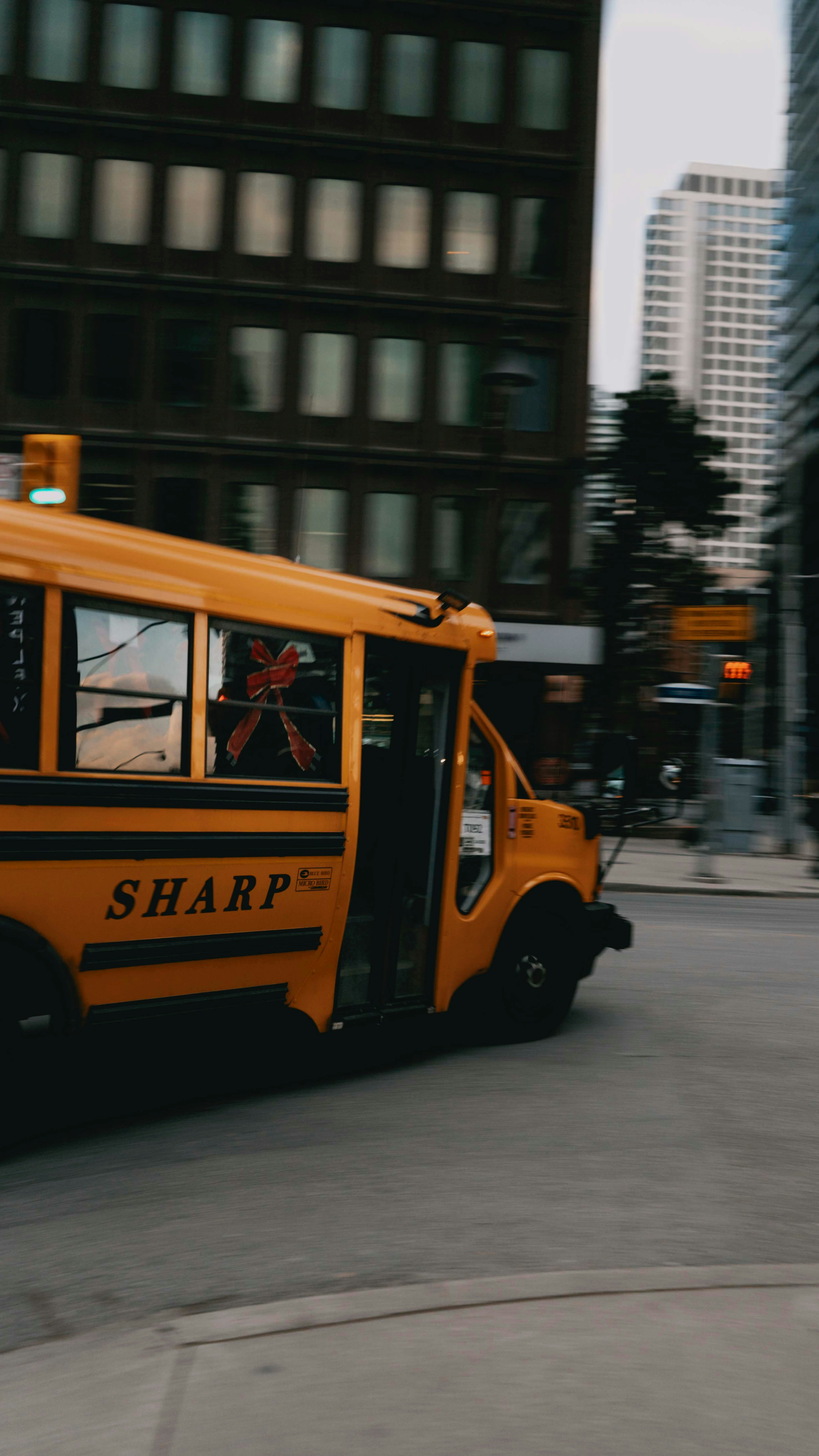 Yellow School Bus in Motion Past a City Street