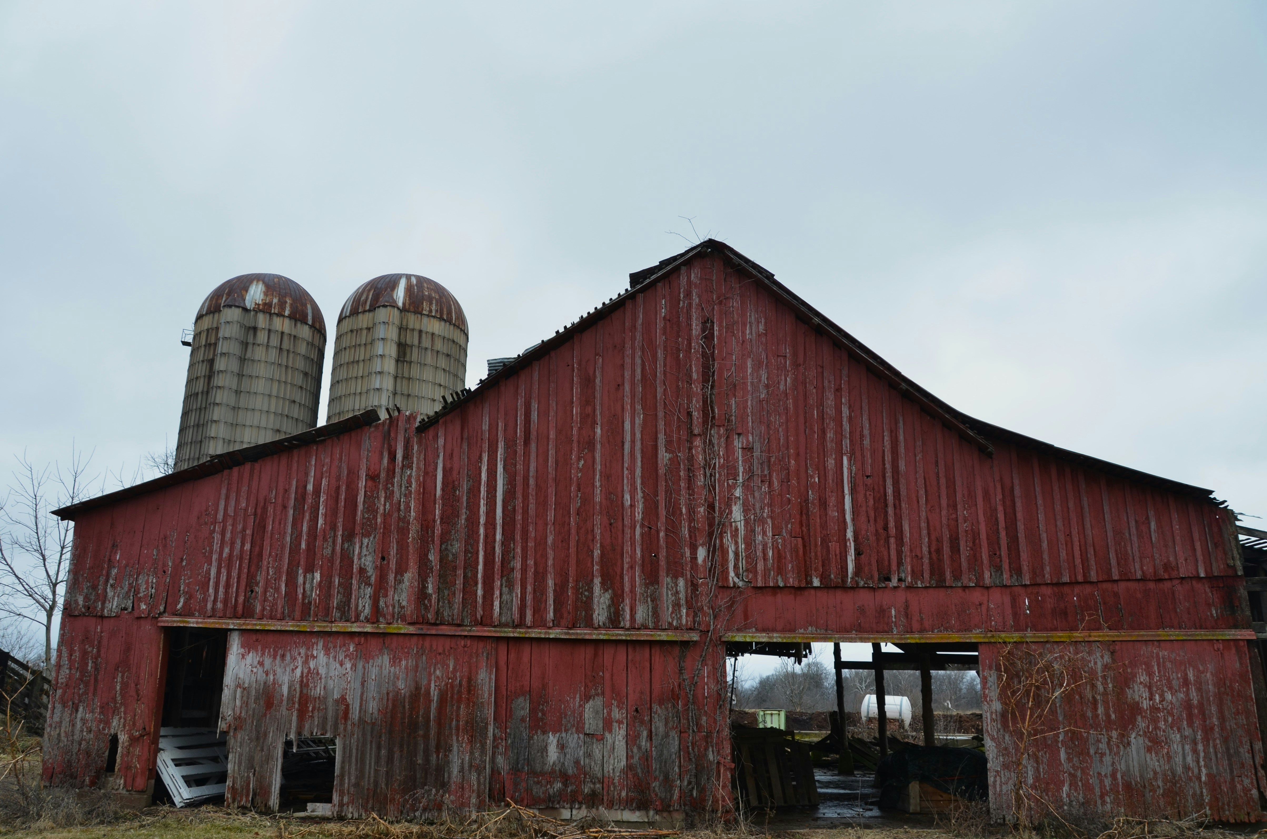 A red barn with two silos on top of it photo – Free Building Image on ...