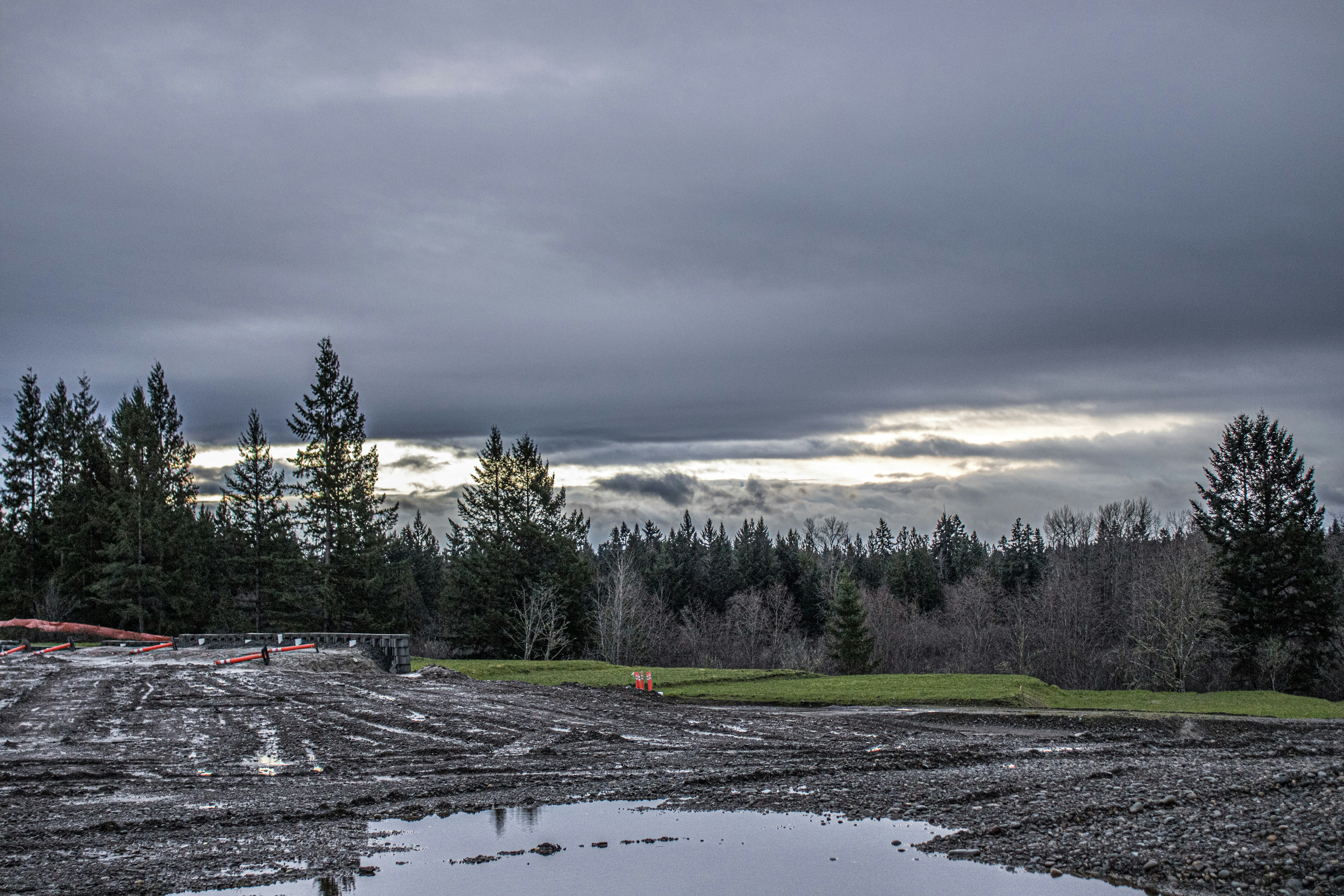 A muddy field with a puddle in the middle of it photo – Free Nature ...