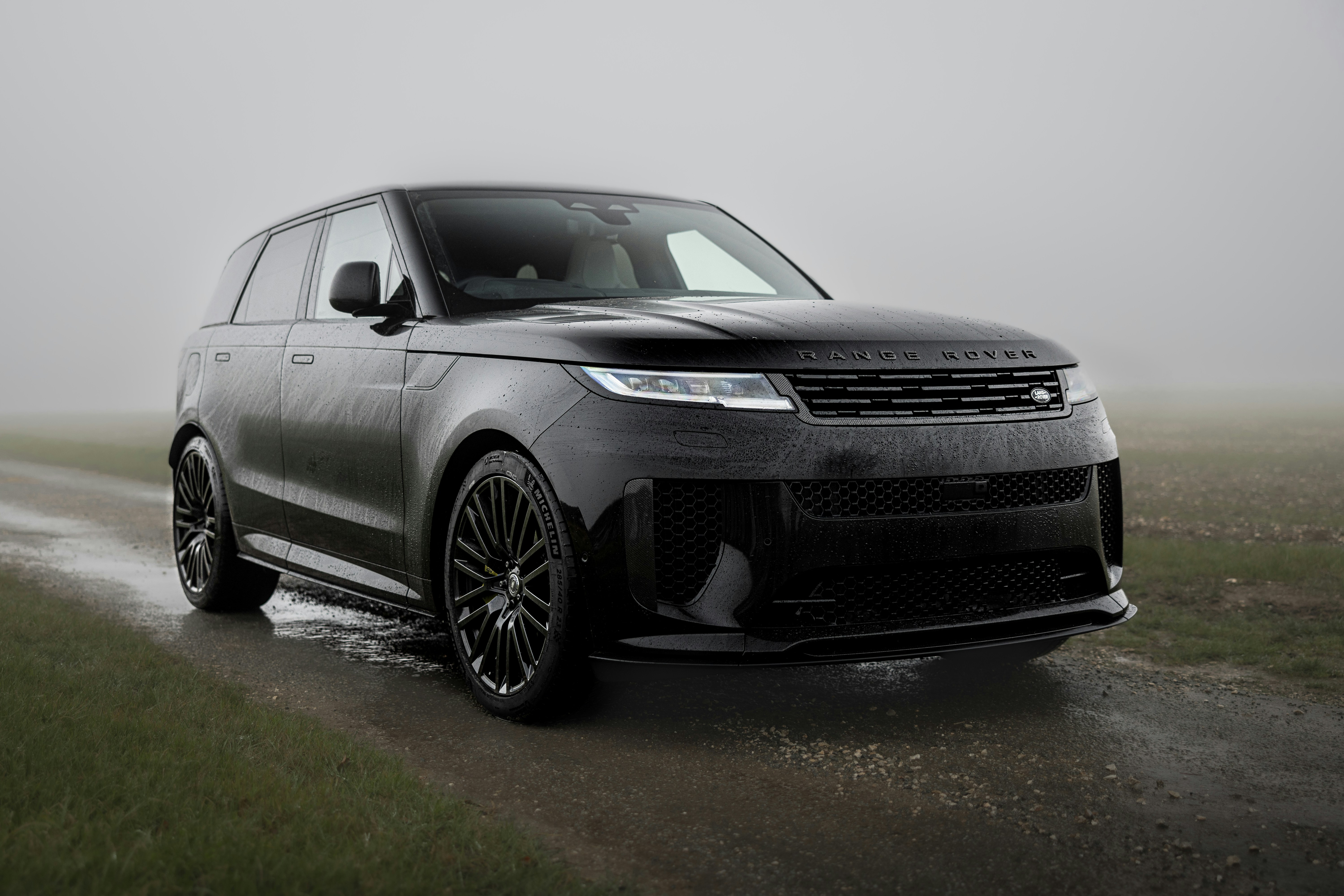 A black range rover driving on a wet road photo – Free Automobile Image ...