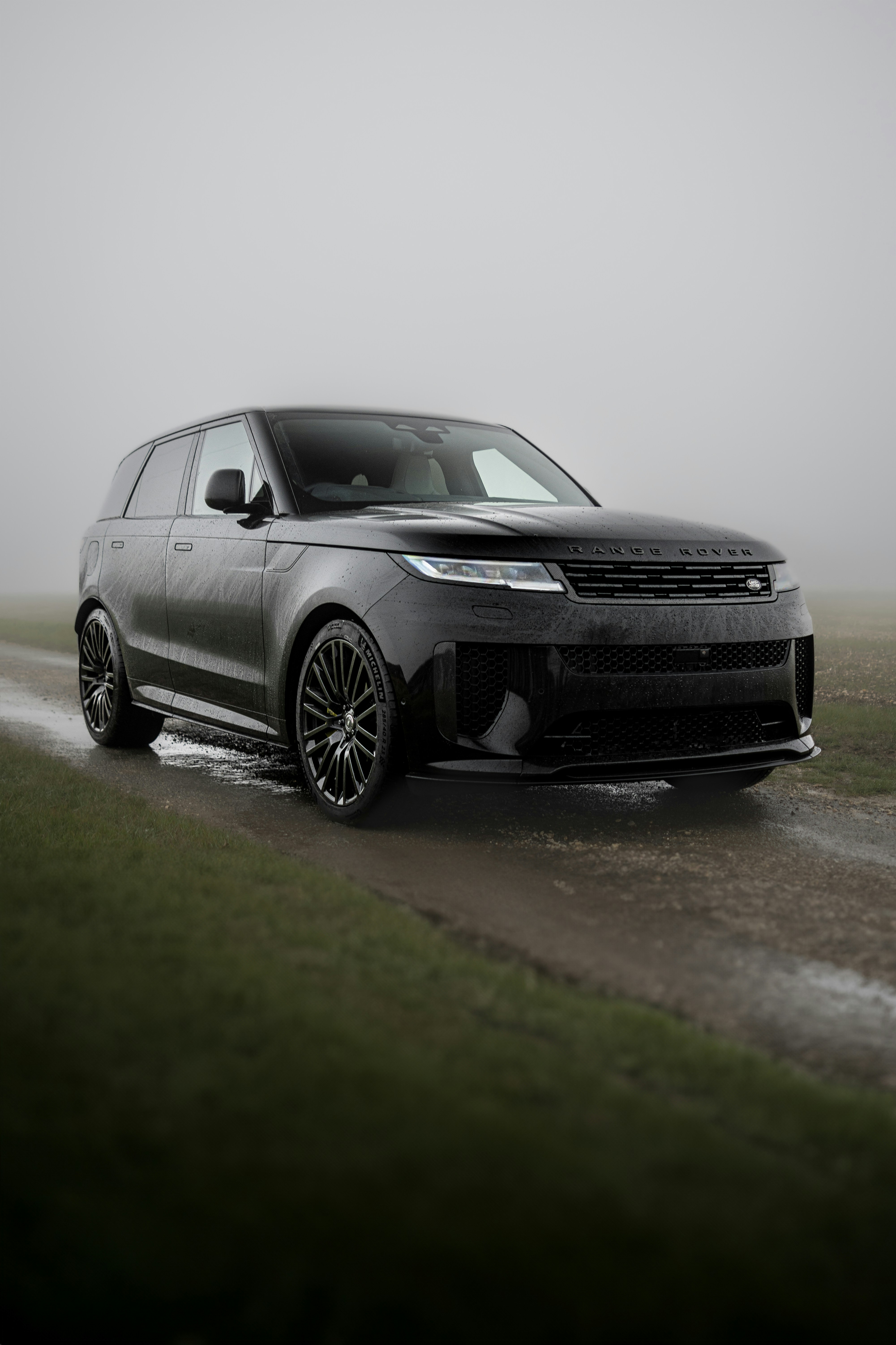 A black range rover driving on a wet road photo – Free Car Image on ...