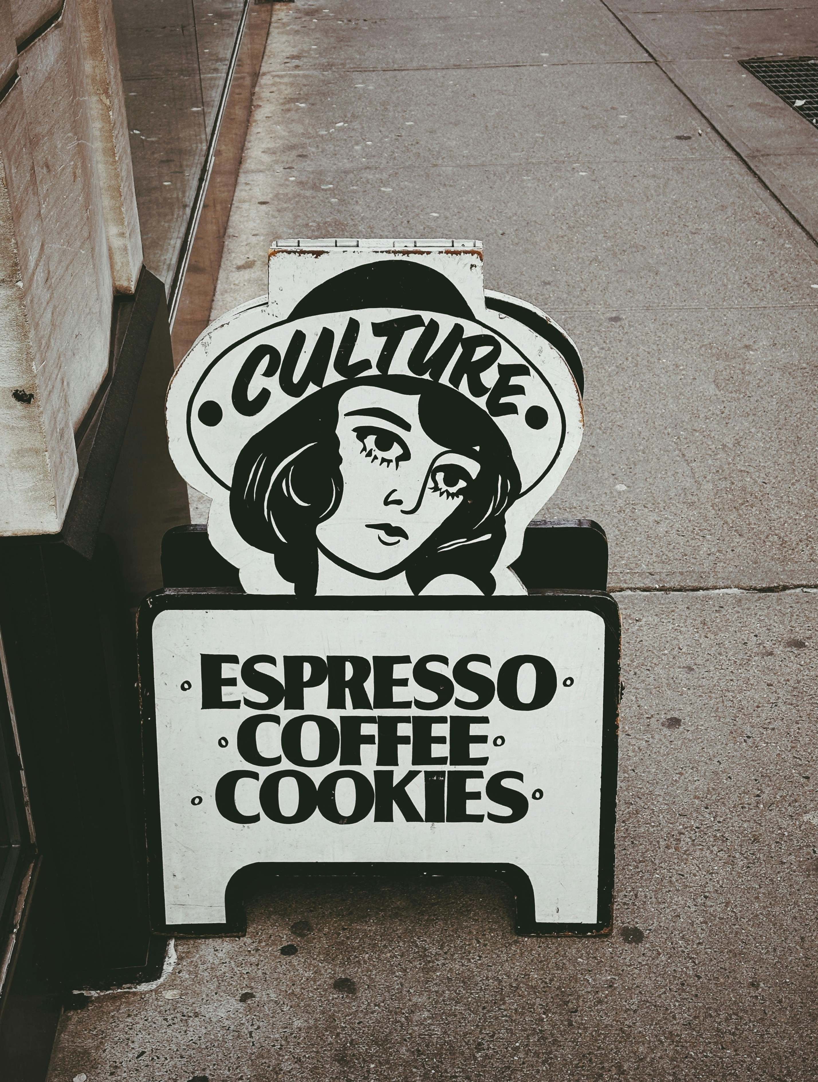 A sign on the side of a building that says culture espresso coffee ...