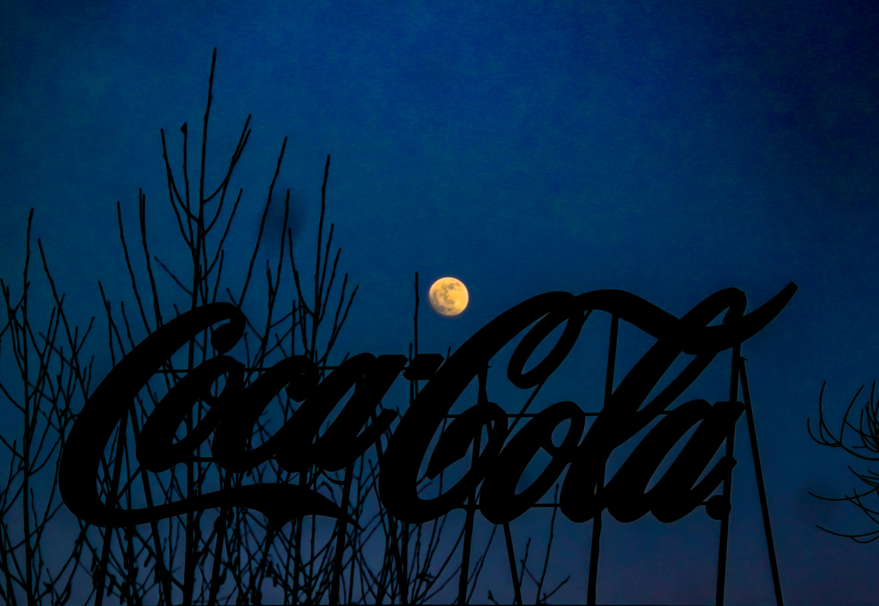 A full moon is seen behind a coca cola sign photo – Free Kazakhstan ...