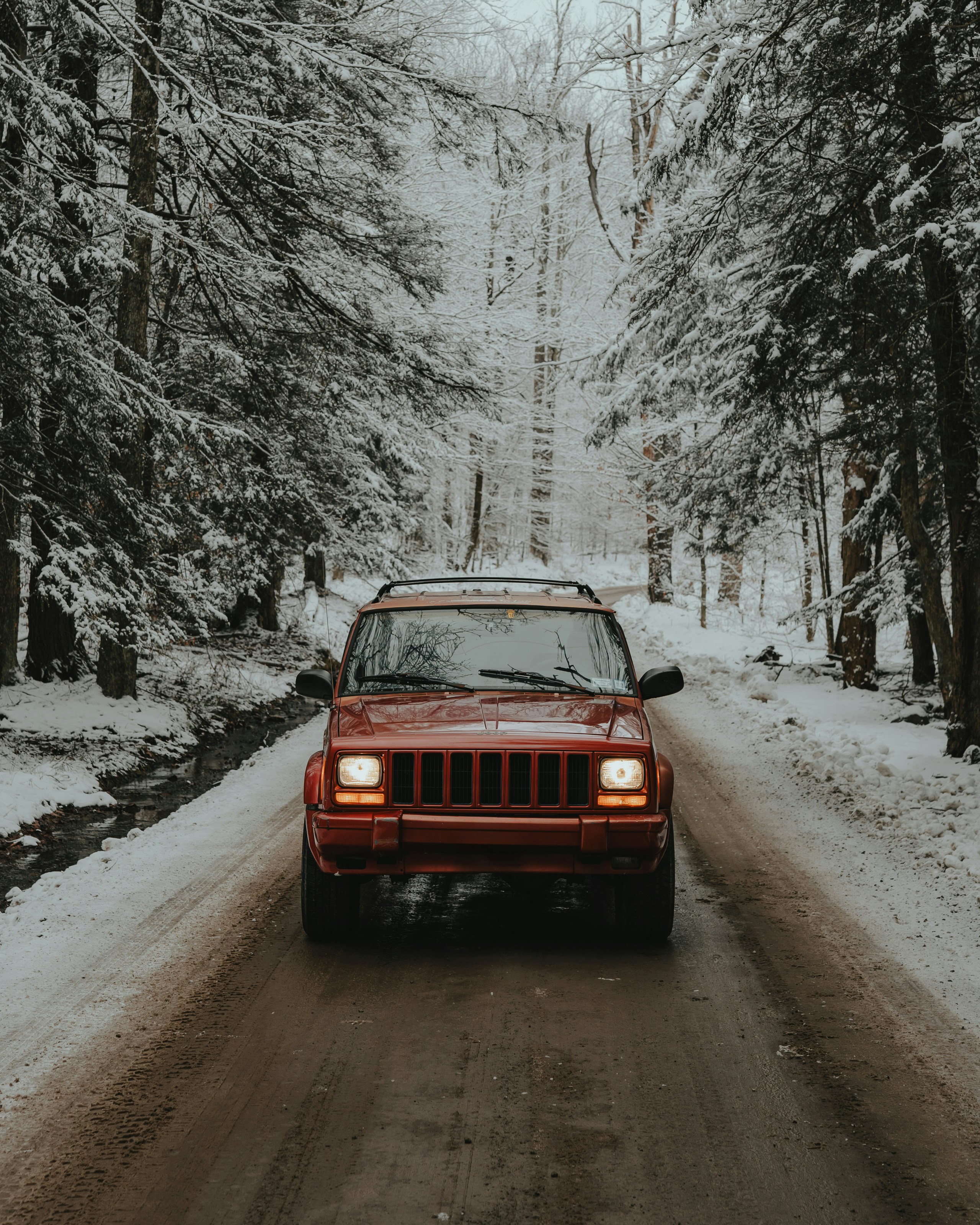 A red jeep driving down a snow covered road photo – Free Catskill ...