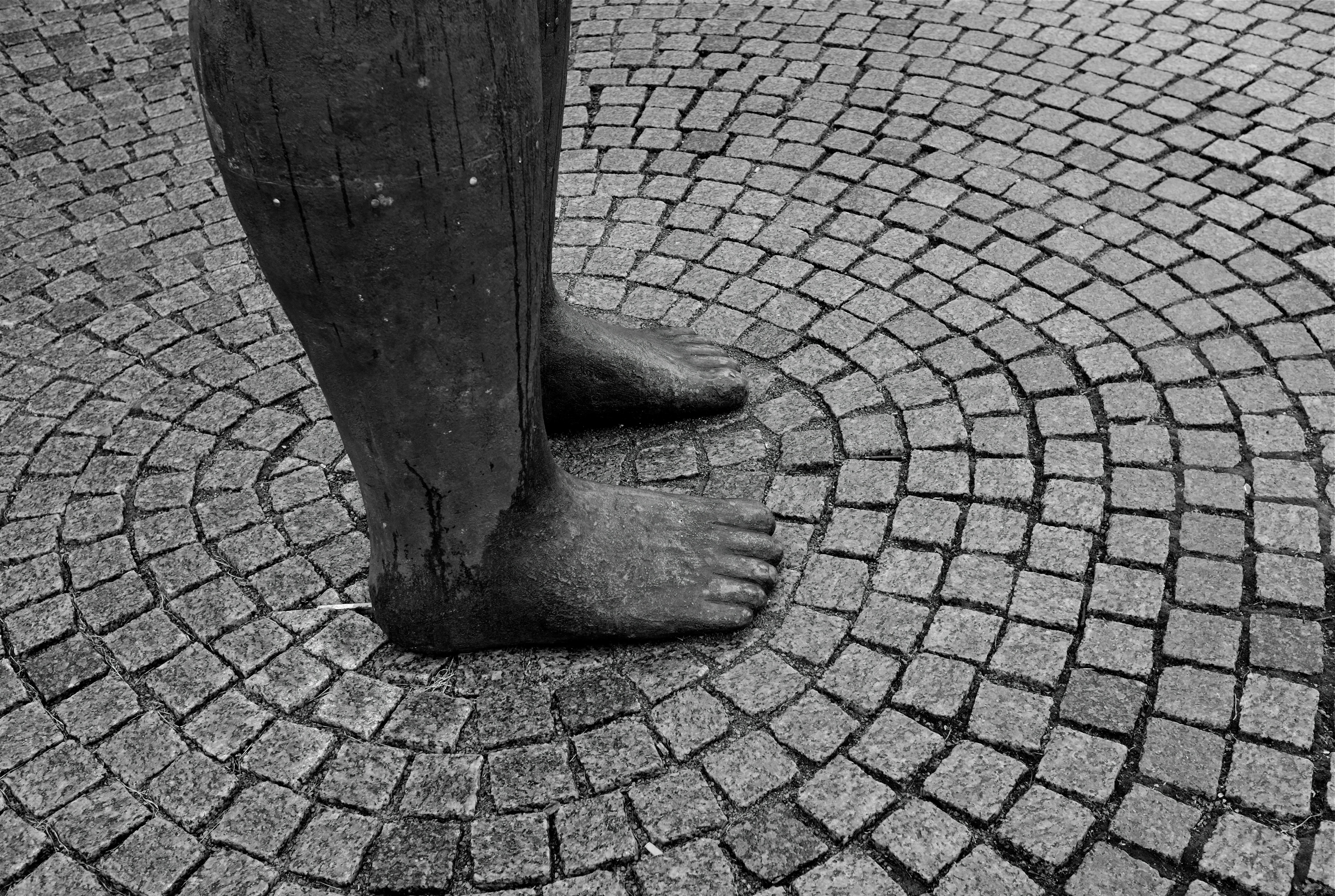 A statue of a foot sticking out of the ground photo – Free Path Image ...