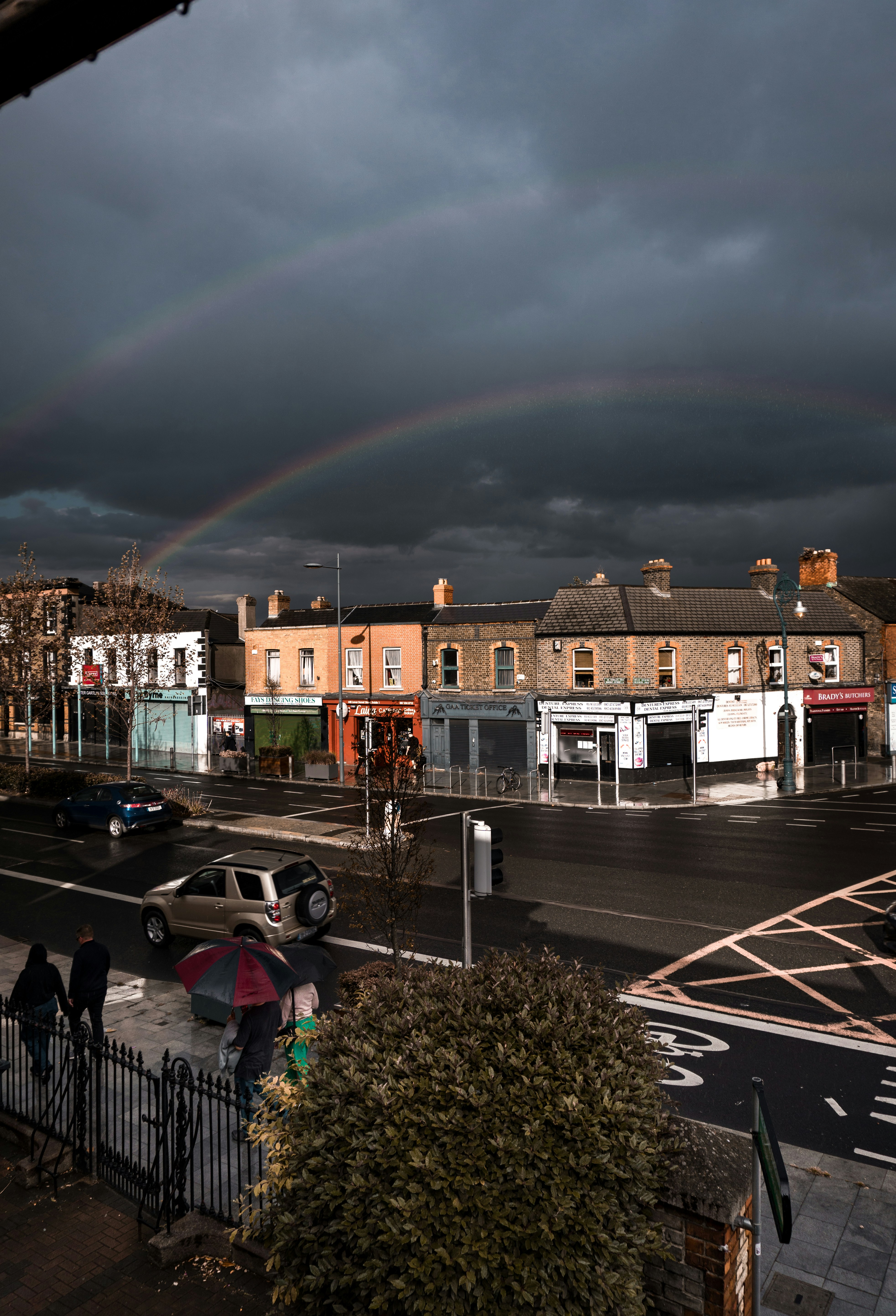 Twin Rainbows Arch Over a Rain-Slick High Street