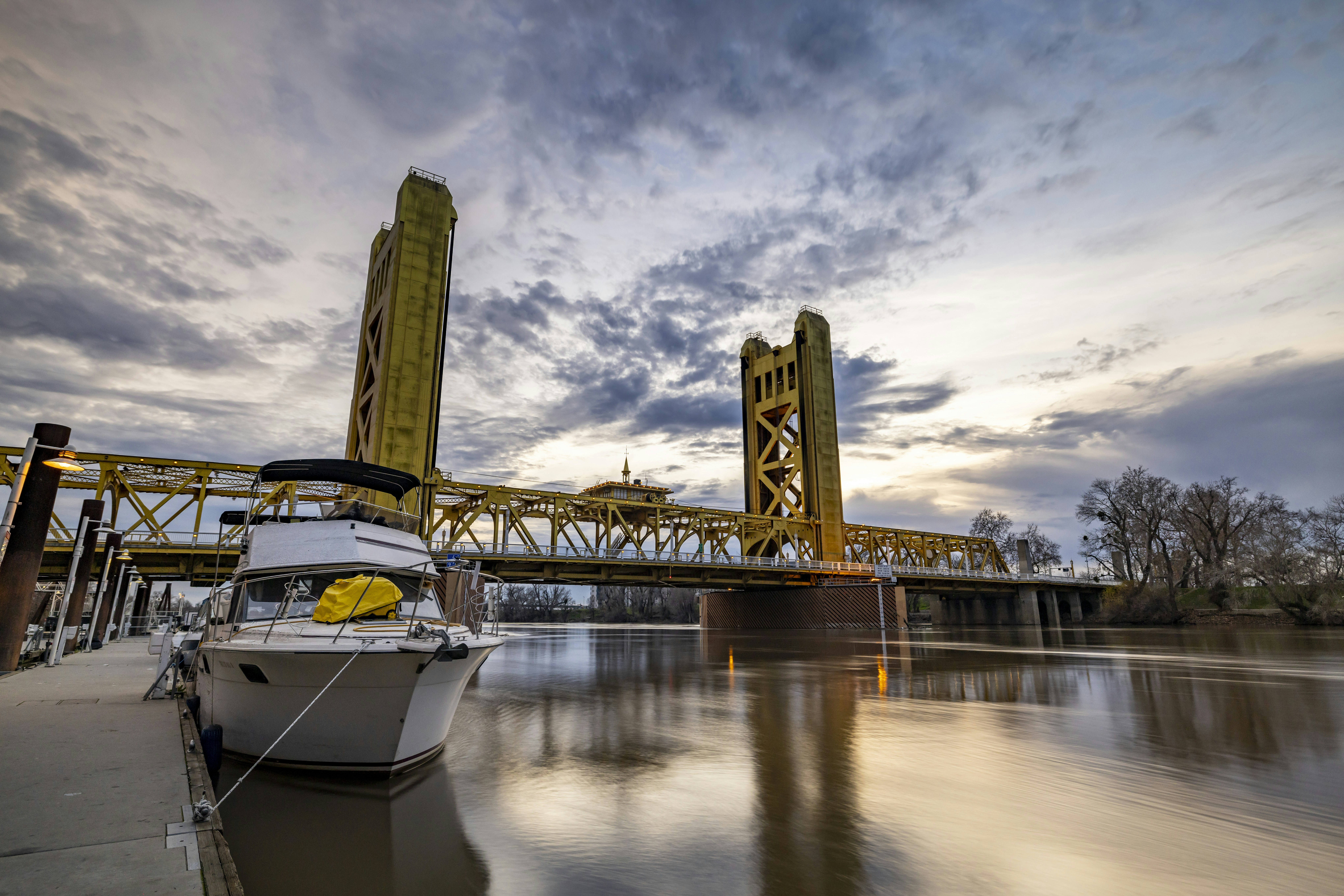 Golden Rails: A Boat at the Bow of a Quiet River Bridge
