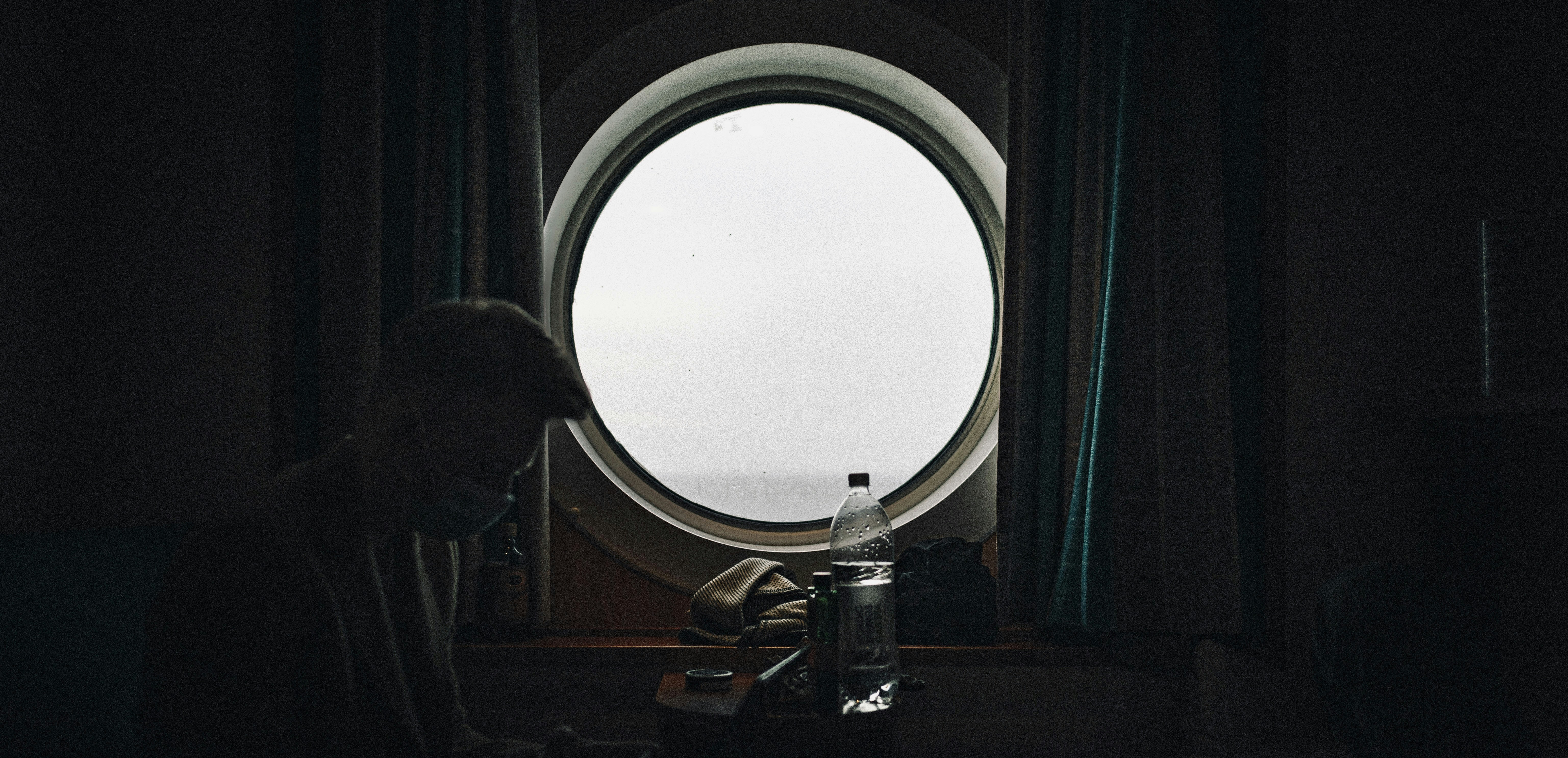a person sitting in front of a round window