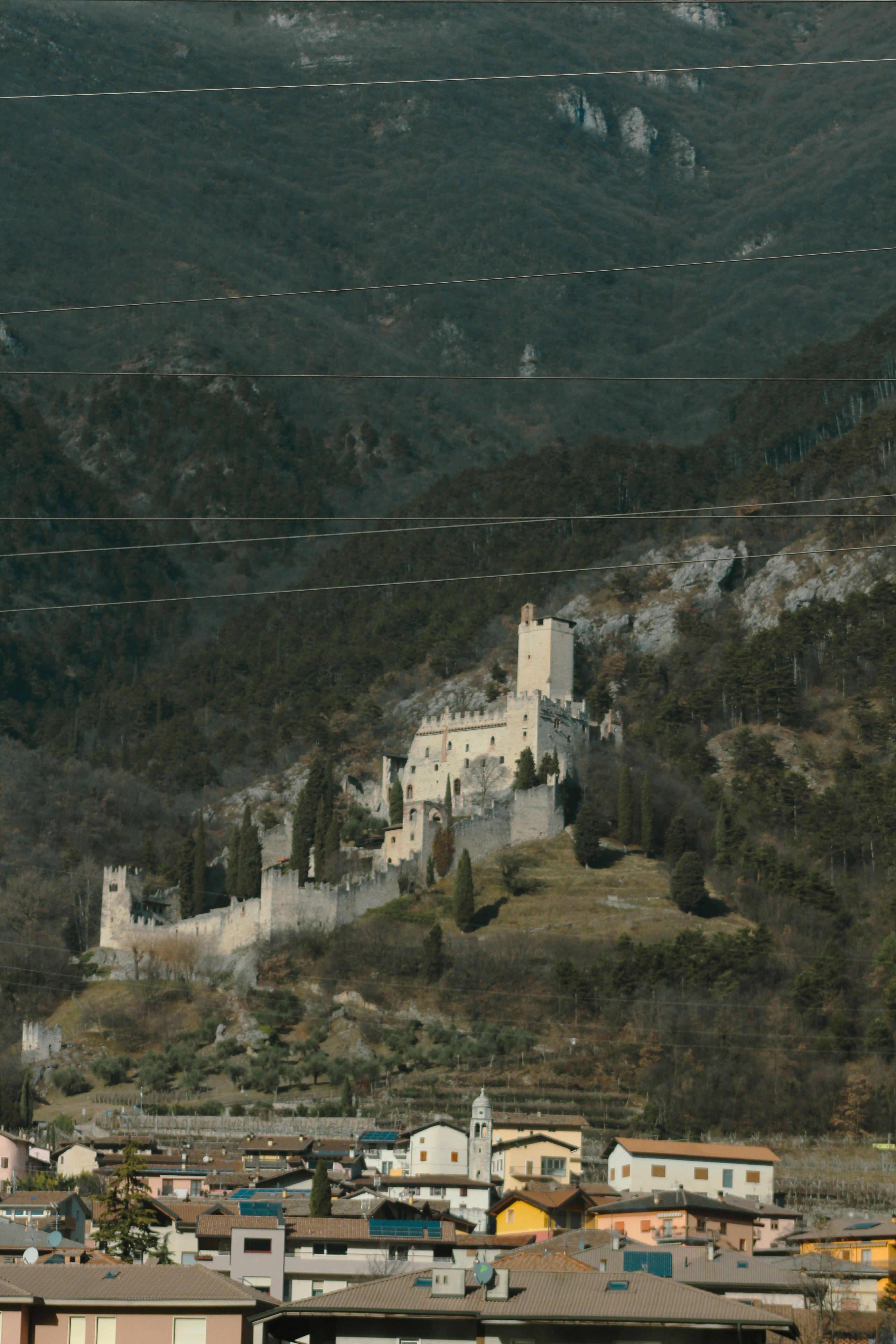 A large white castle sitting on top of a lush green hillside photo ...