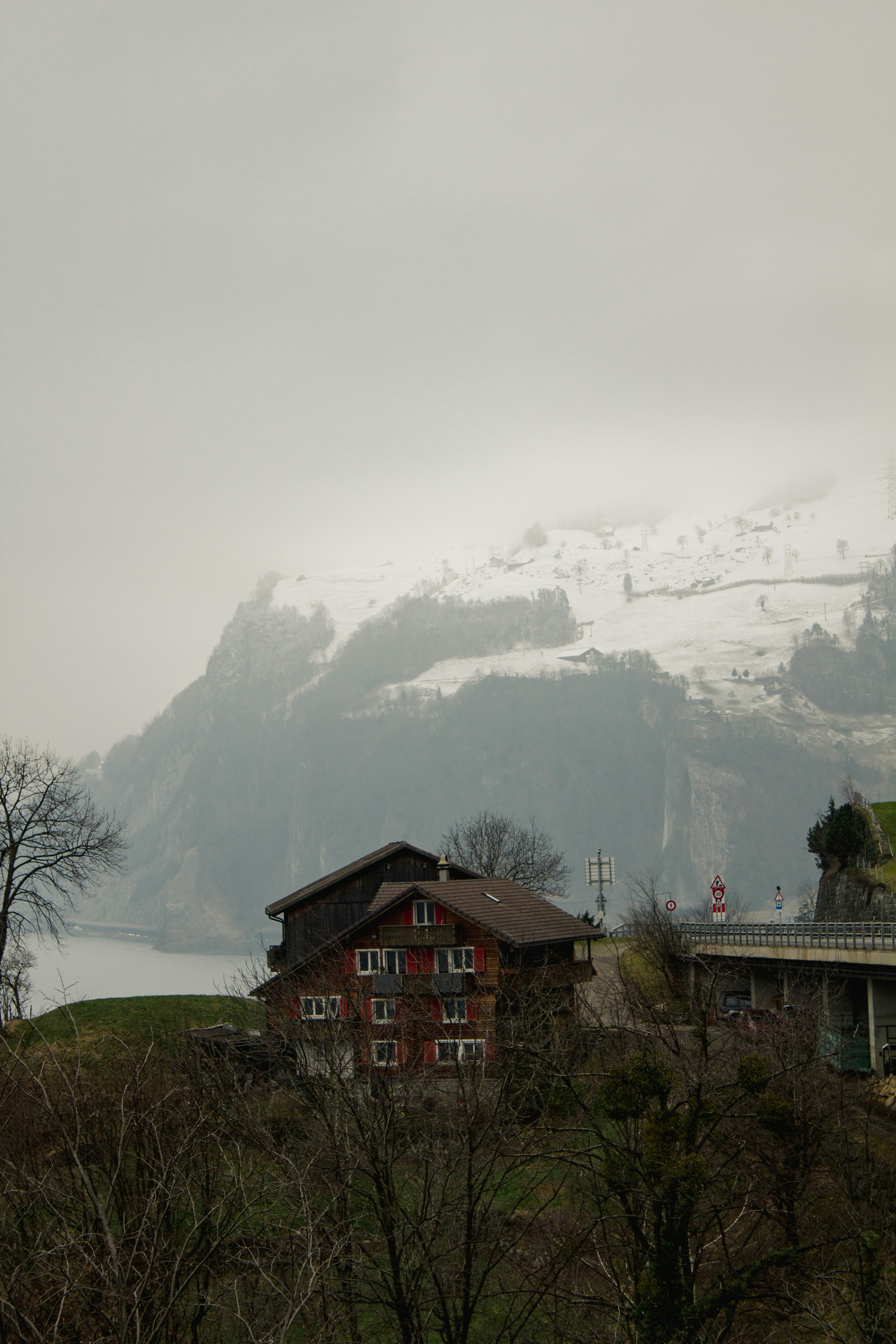 Lakeside Chalet Beneath Winter Mist and Snow-Dusted Alps