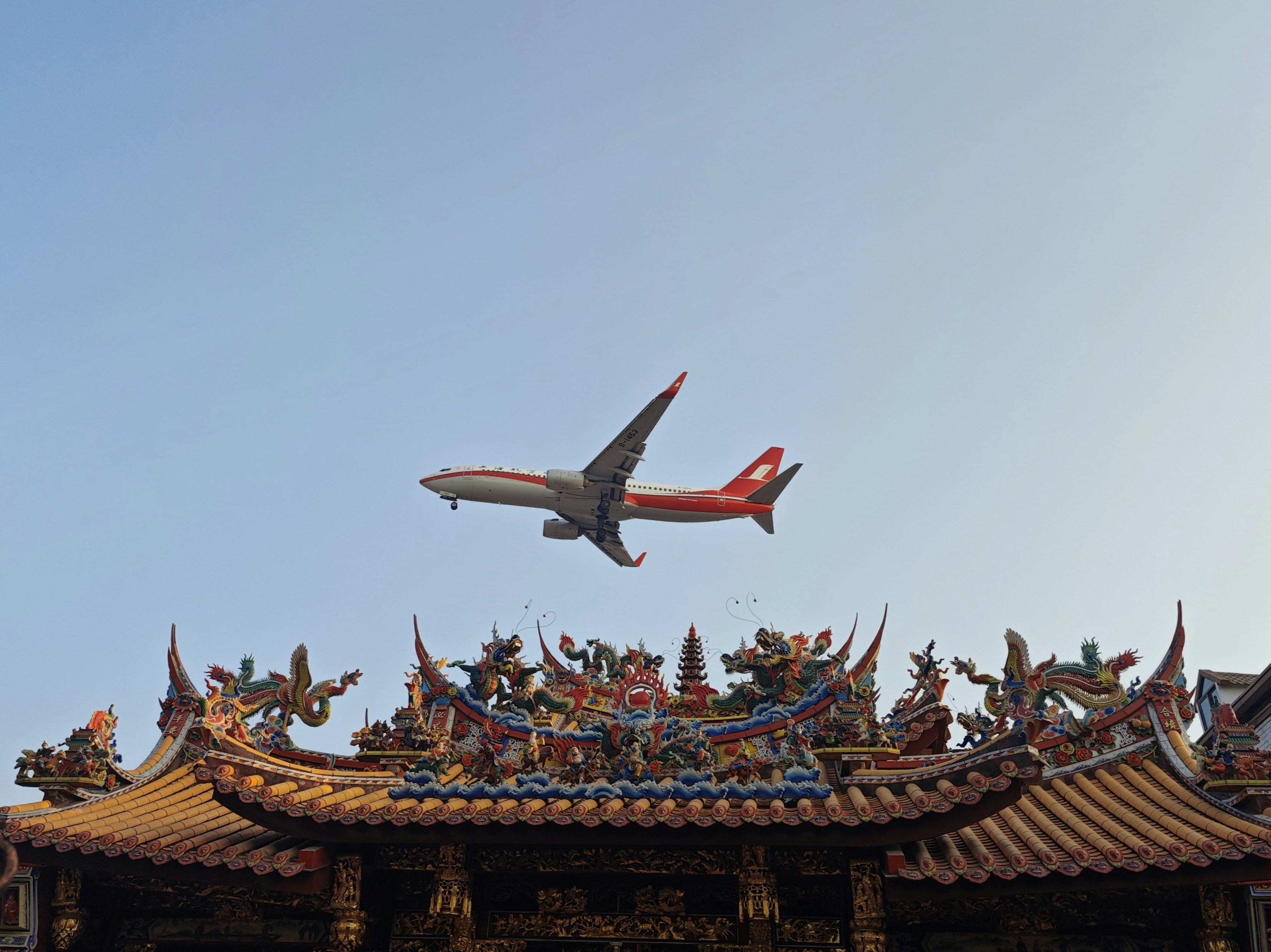 An airplane is flying over a chinese temple photo – Free Building Image ...