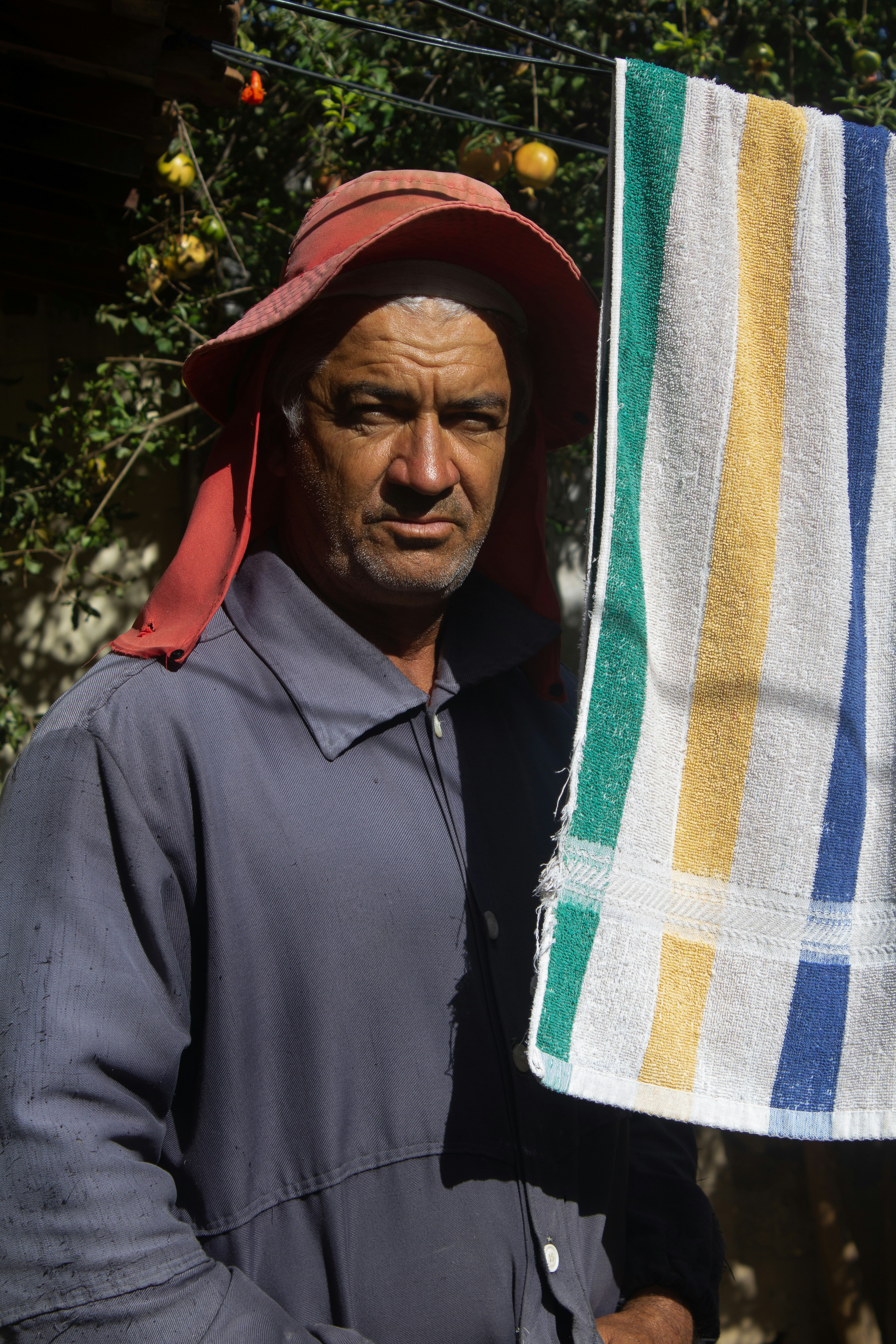 Red-Hooded Portrait Framed by a Rainbow of Towels