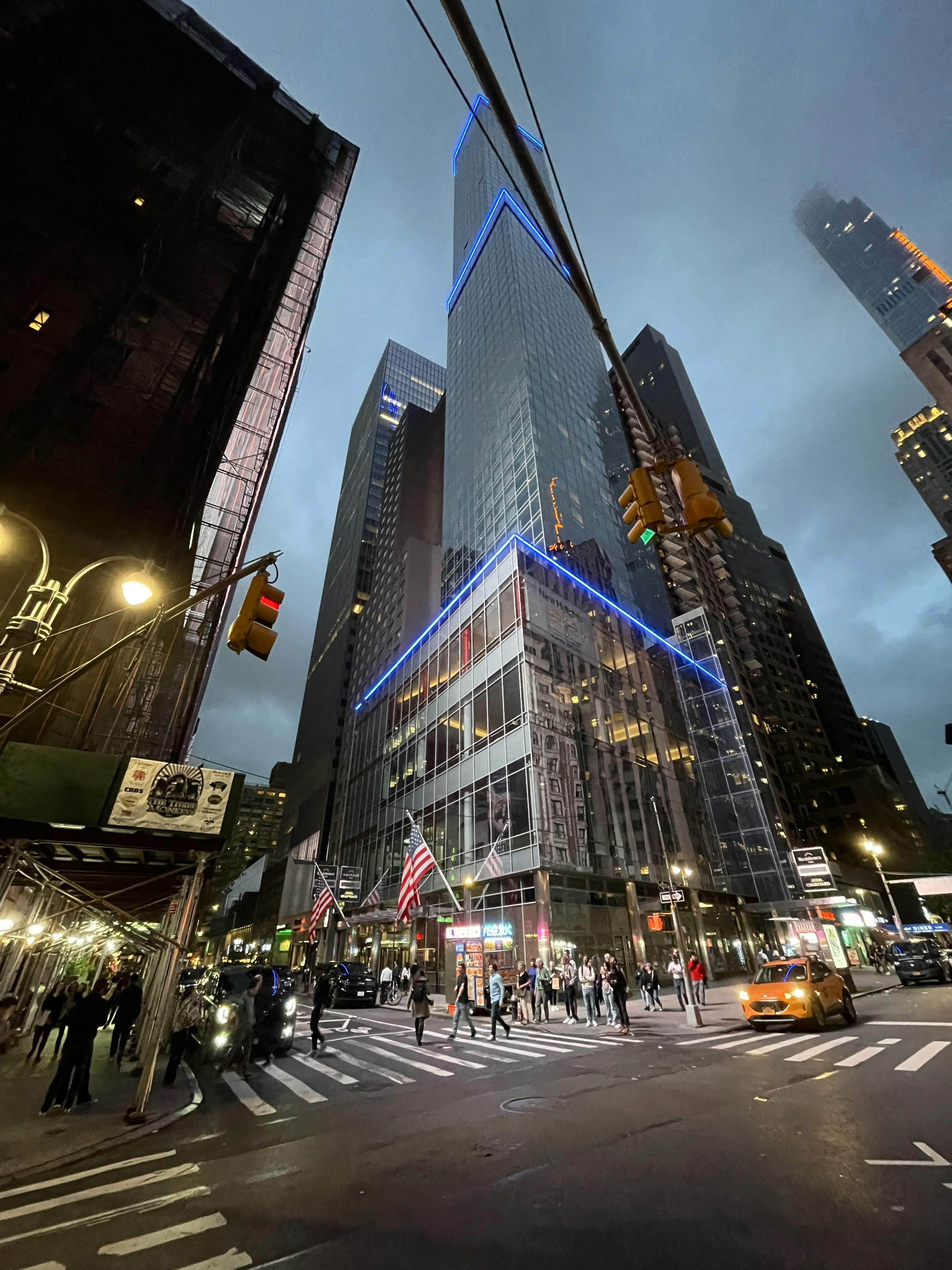 A group of people crossing a street in front of a tall building photo ...