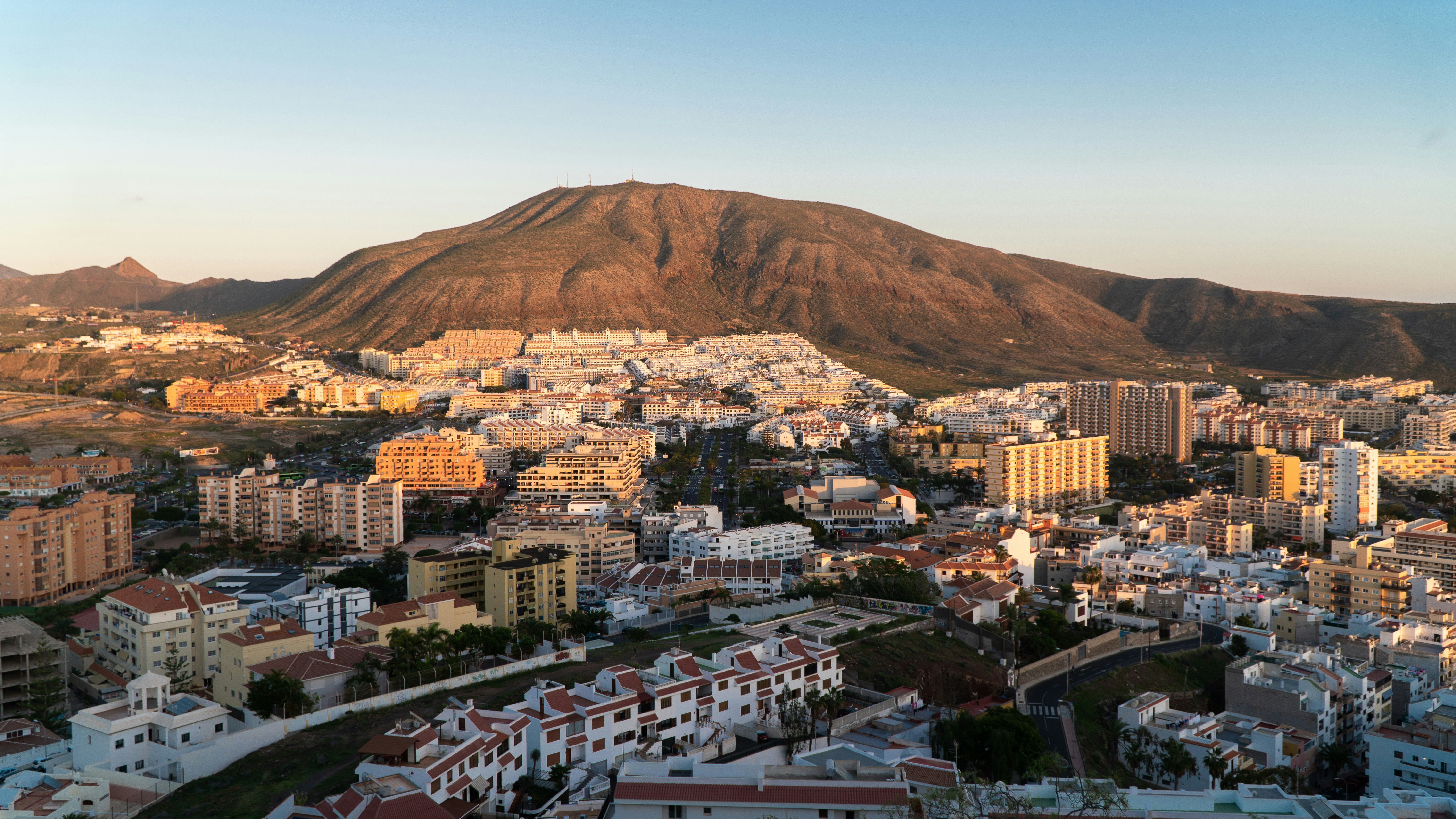 Golden Hour City Nestled Against a Sunlit Mountain Ridge