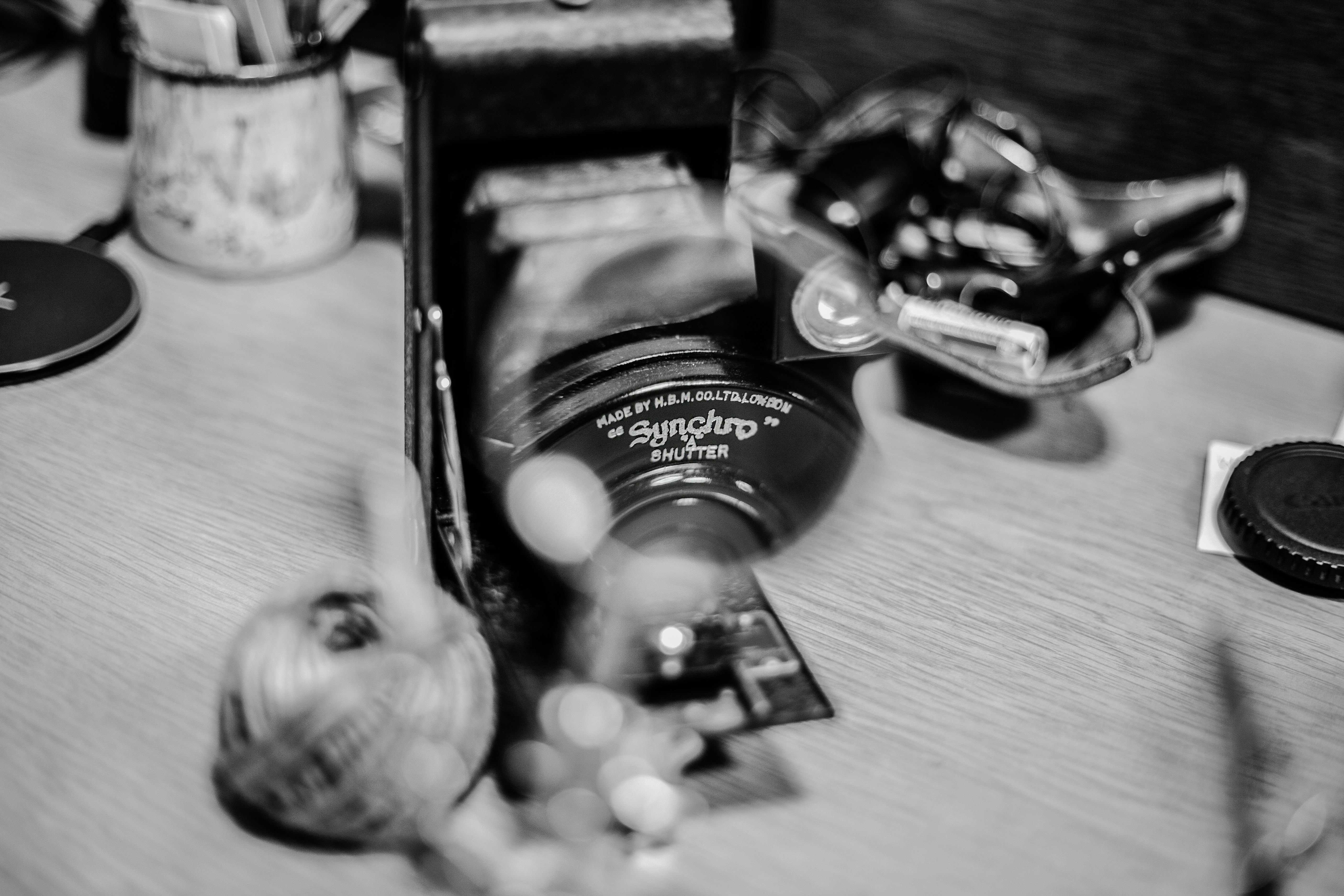 Centered Lens on a Desk: A Mono Still-Life of Camera Gear