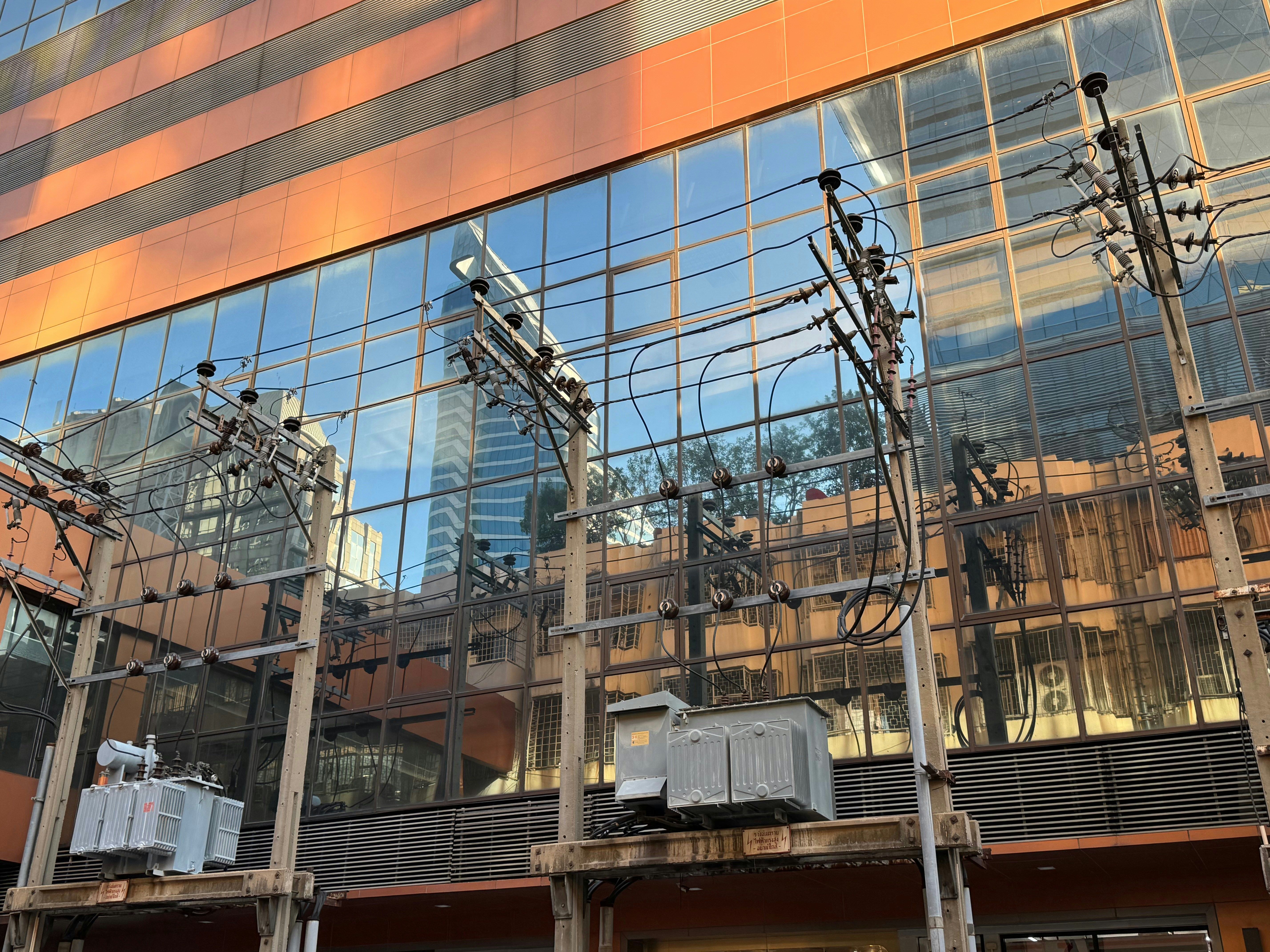 Orange Facade, Reflected Skyline: A Glassy City Moment