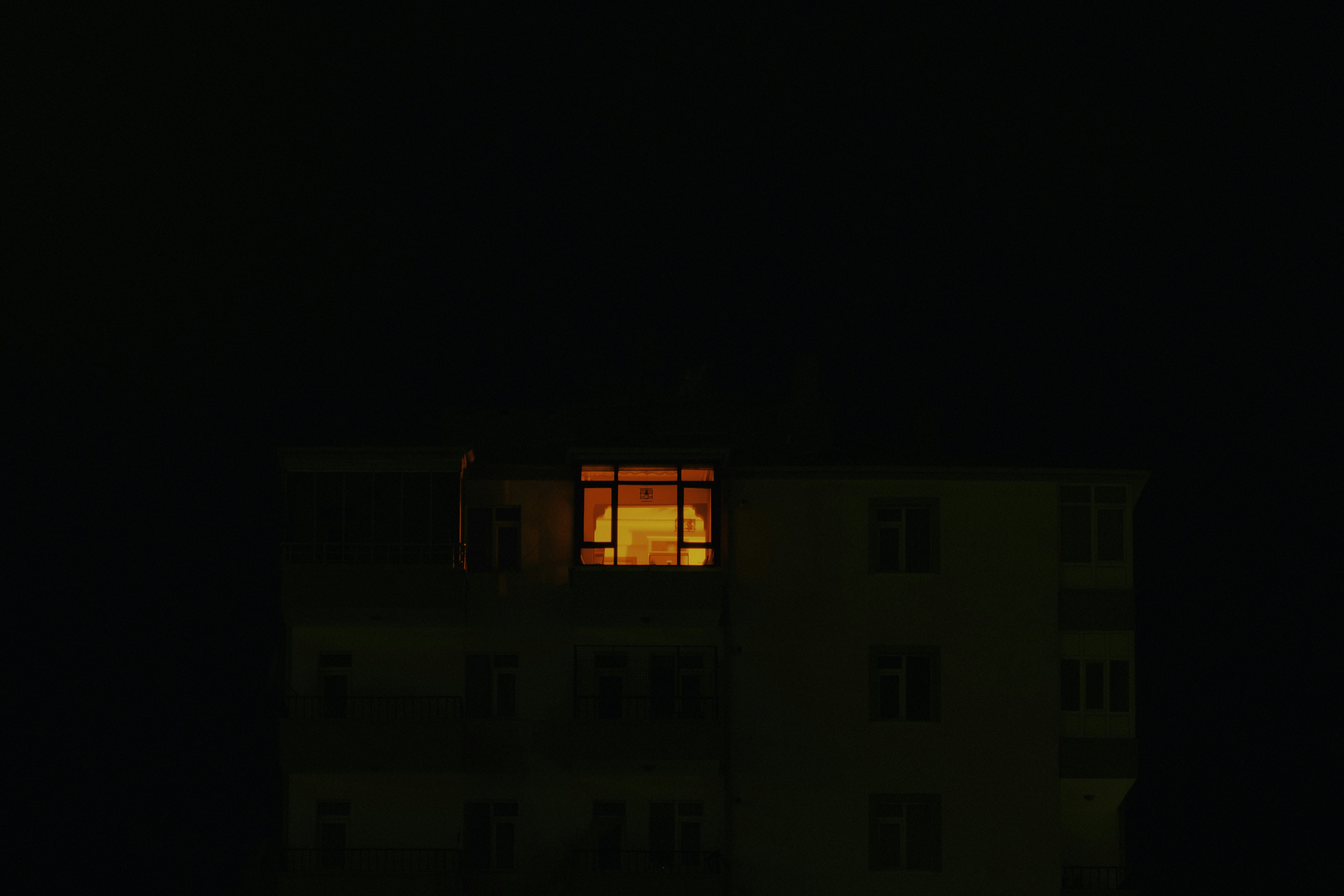 A building with a window lit up at night photo – Free Building Image on ...