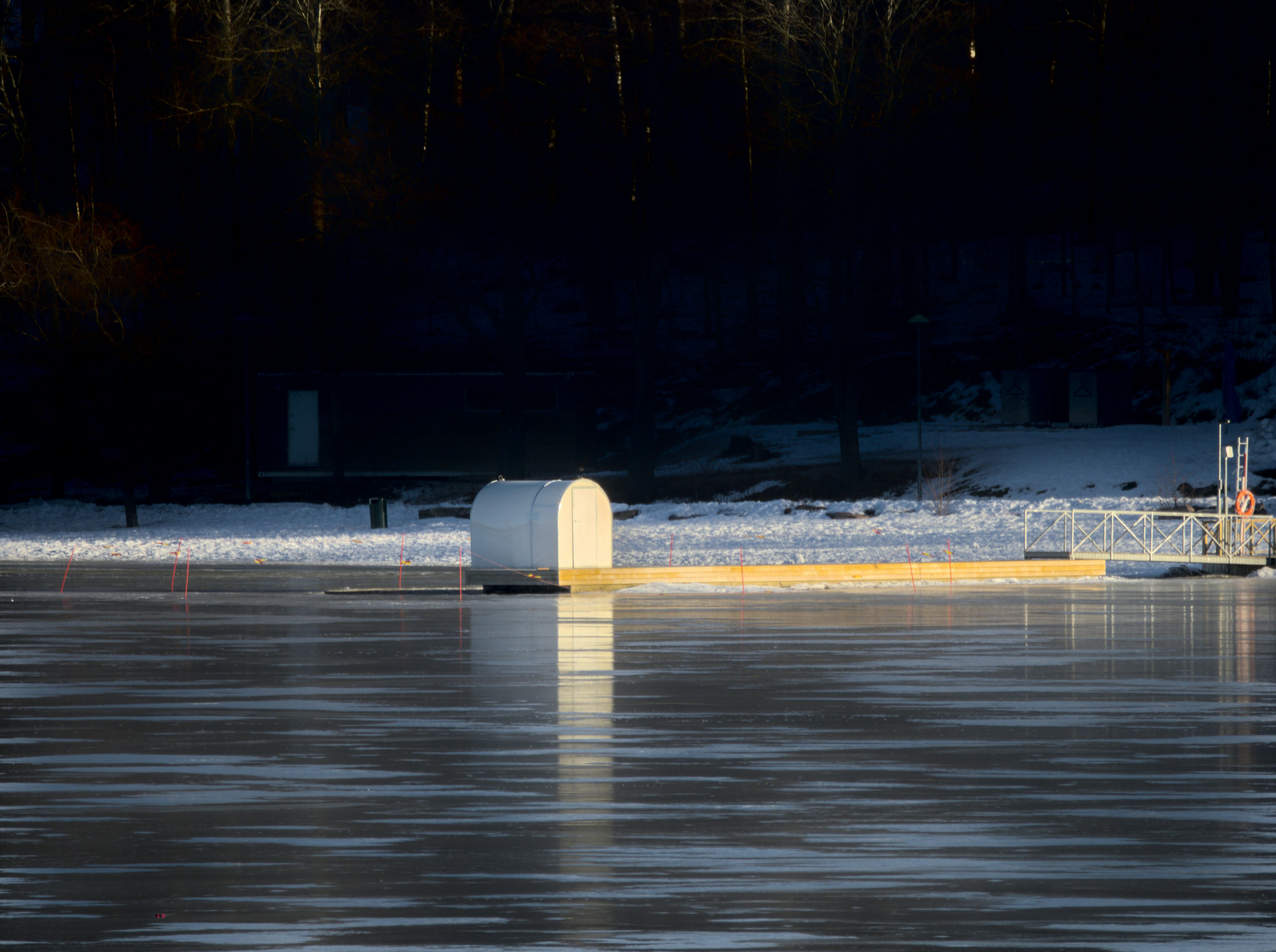 Curved Boathouse on a Quiet Frozen Lake