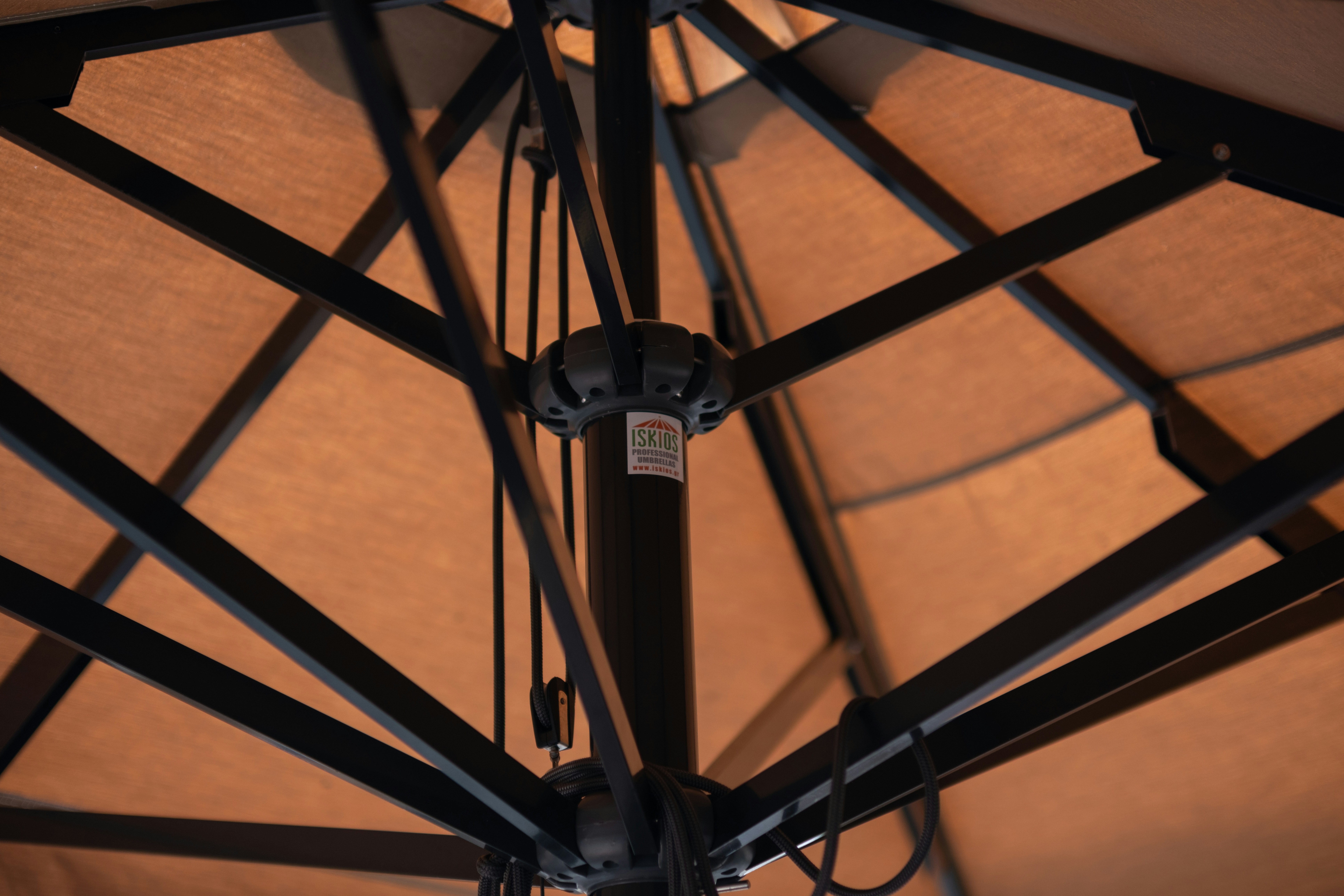 Inside the Orange Canopy: Macro Detail of Umbrella Ribs and Hub