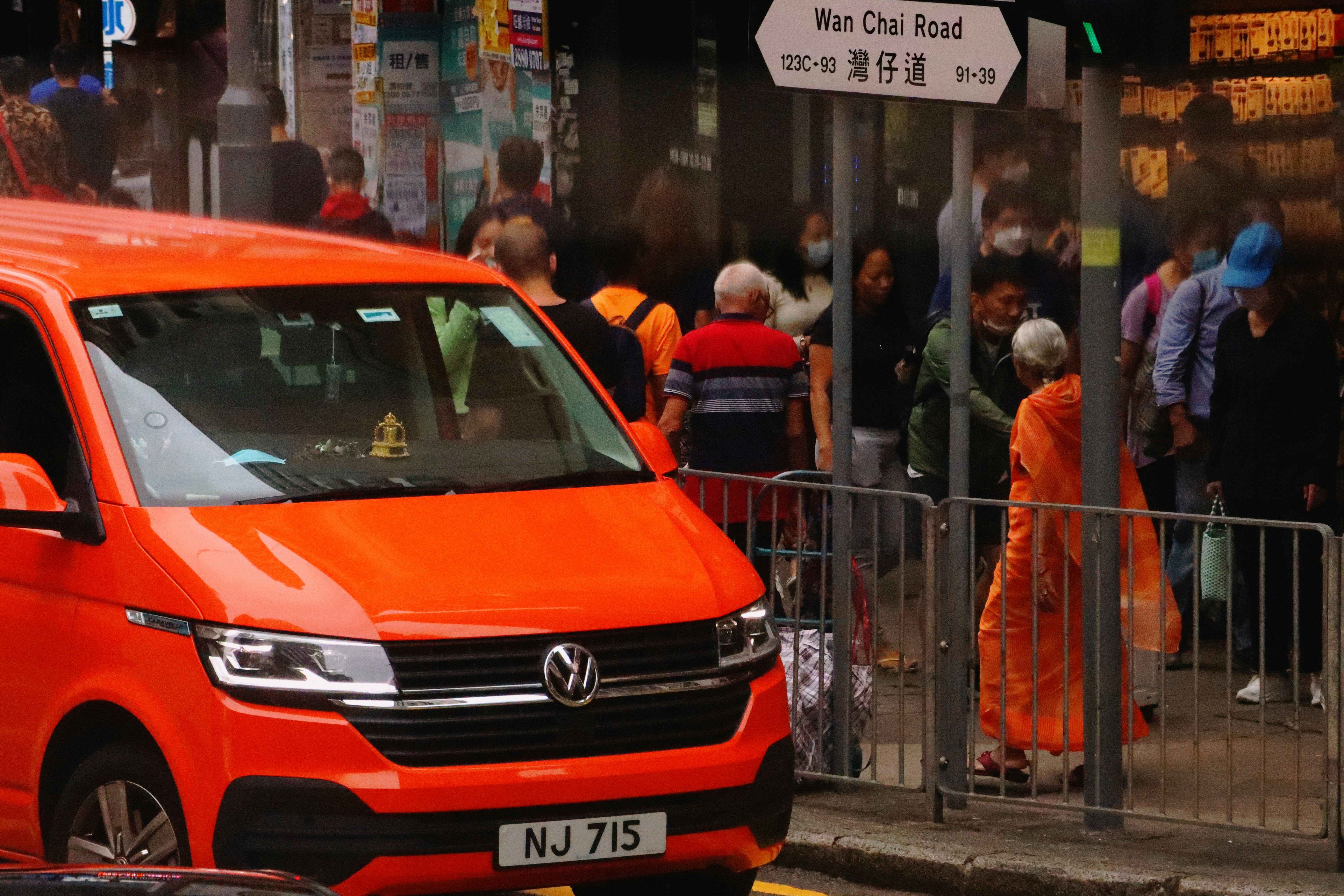 Bright orange VW van anchors a crowded Wan Chai curbside scene
